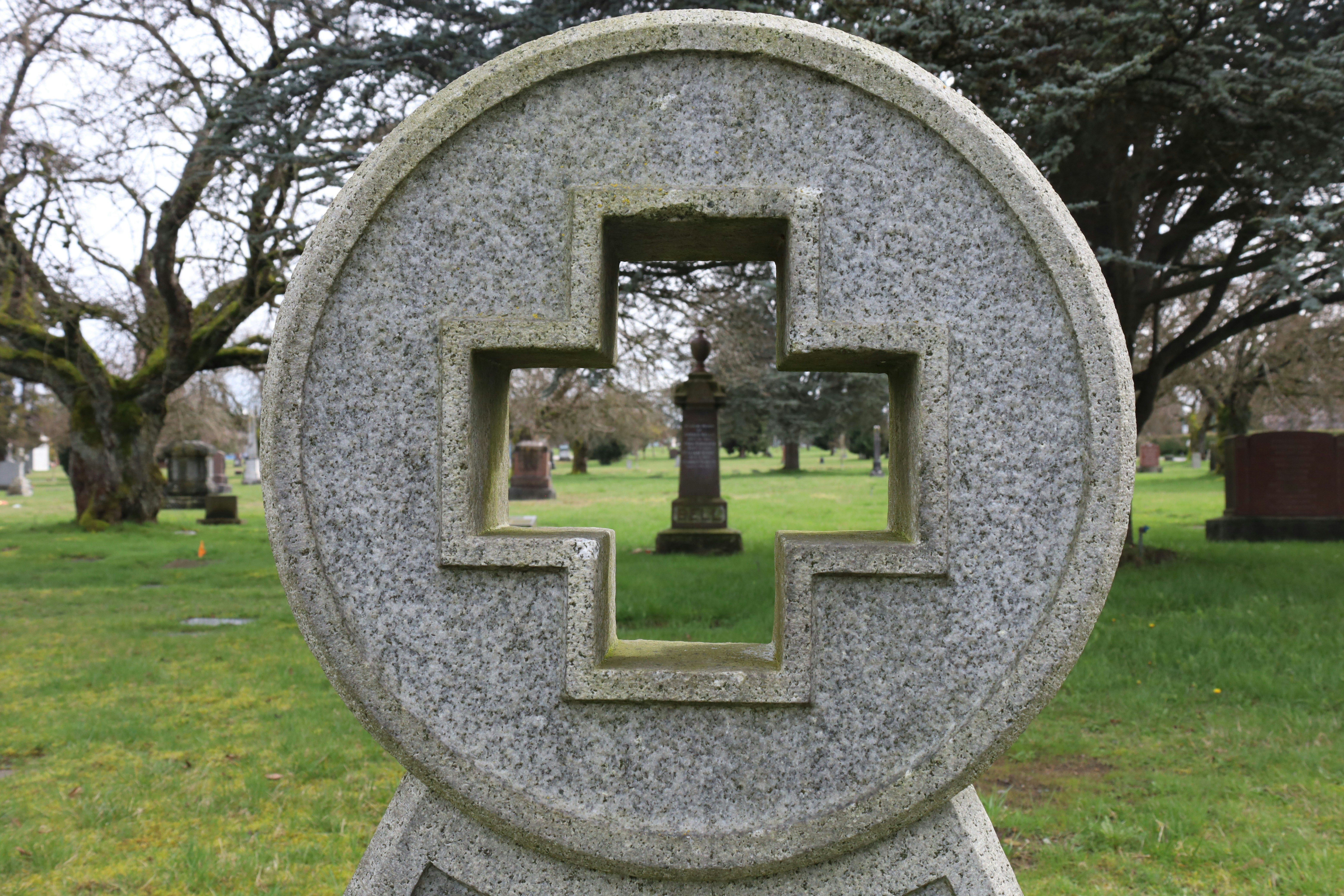 Circle of Stone: A Cross-Shaped Frame Framing a Distant Statue in a Quiet Cemetery