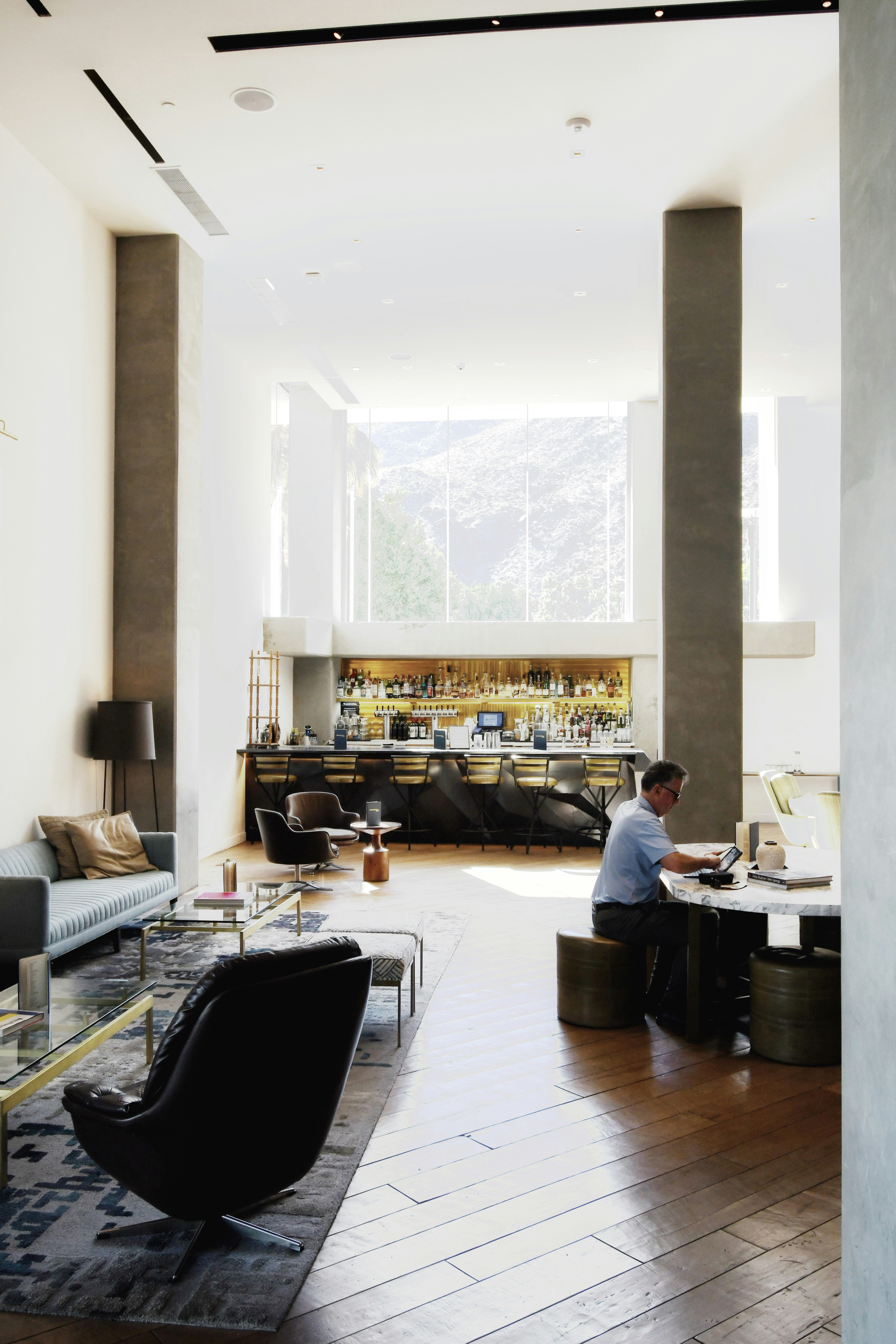 A hotel lobby in Palm Springs with a man working at a laptop