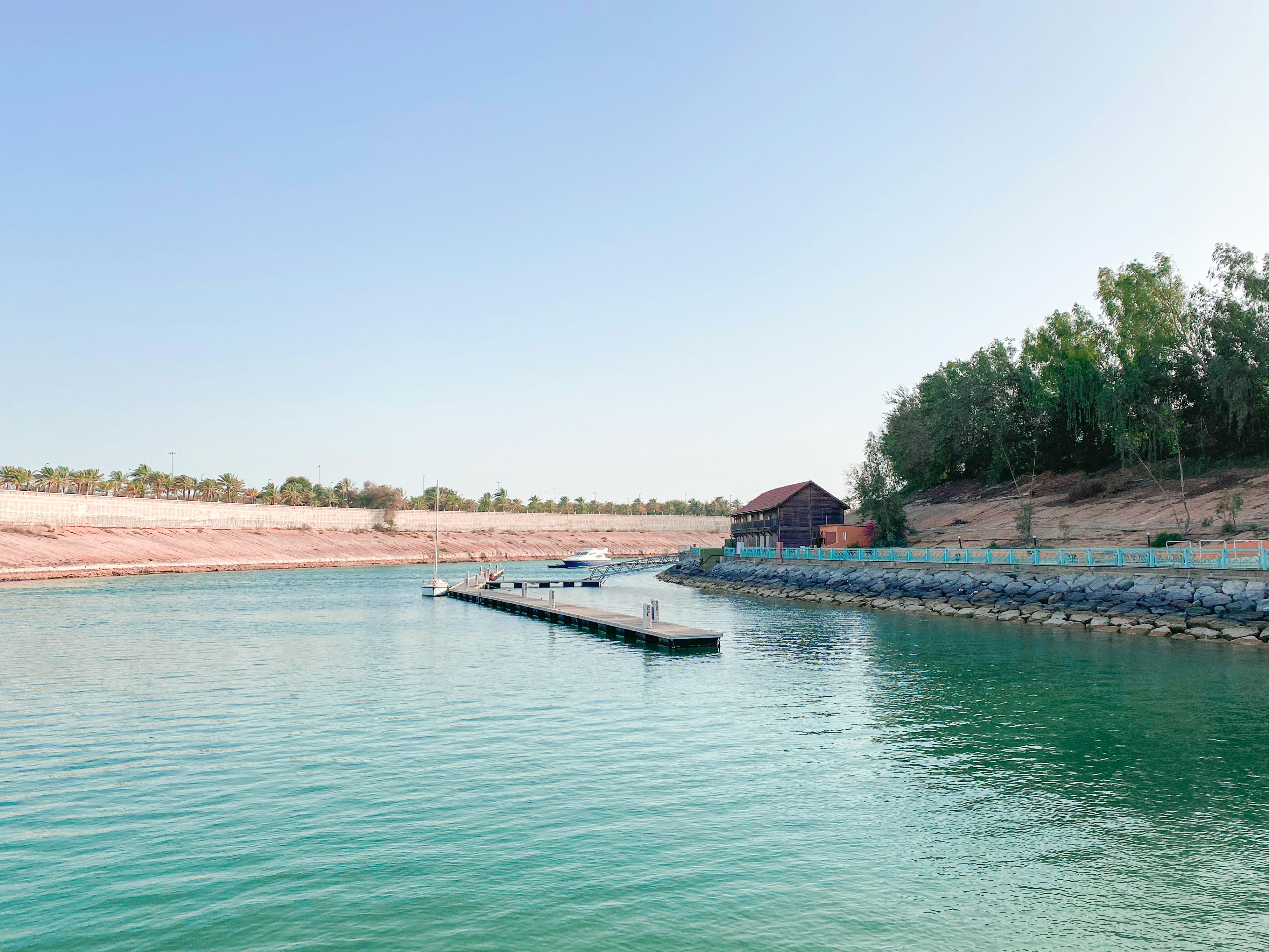 Floating Dock on Turquoise Reservoir Framed by Red Earth and Green Canopy