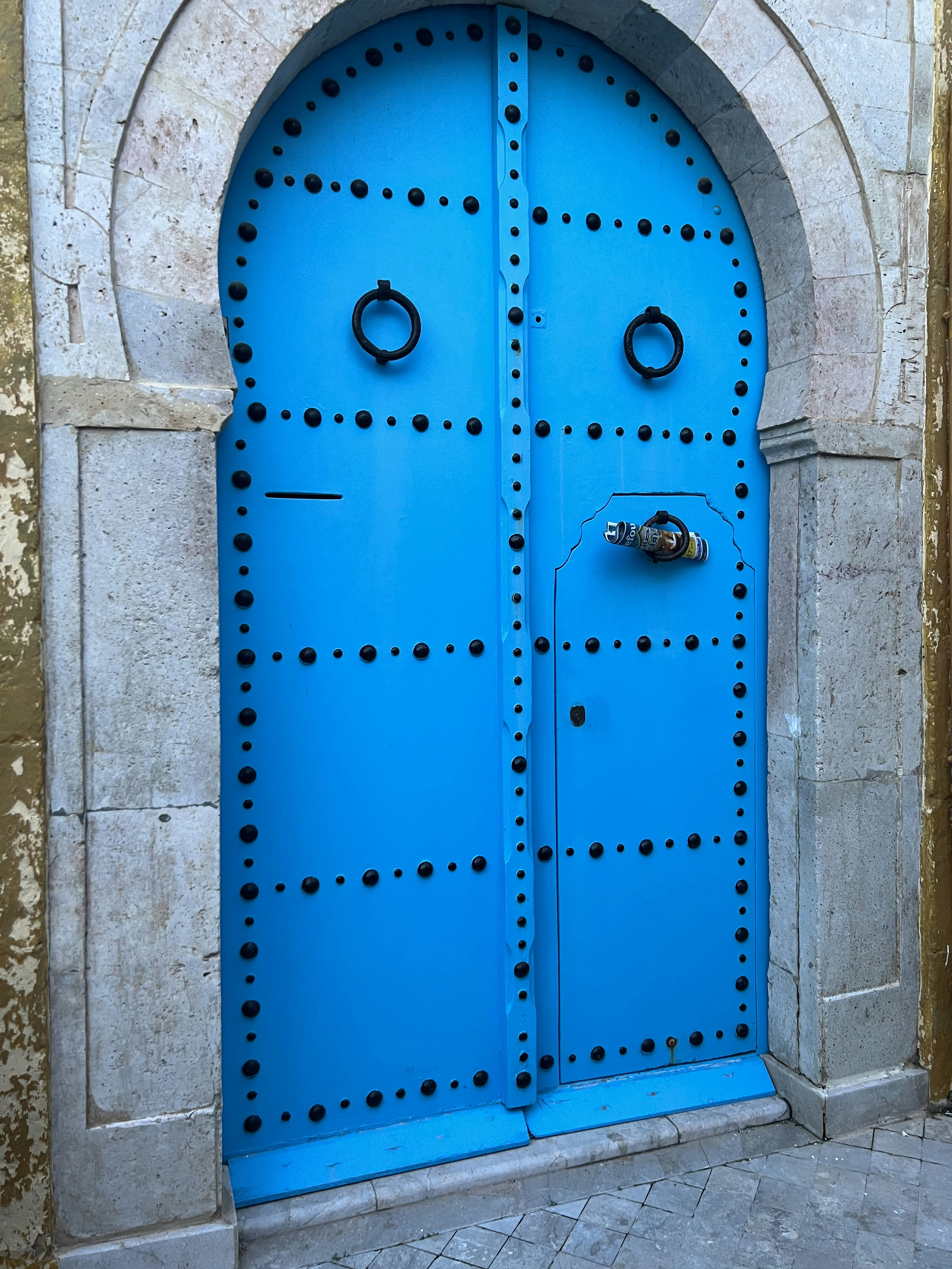 Cerulean Rivet Gate: Archway of Stone Framing a Bold Blue Door