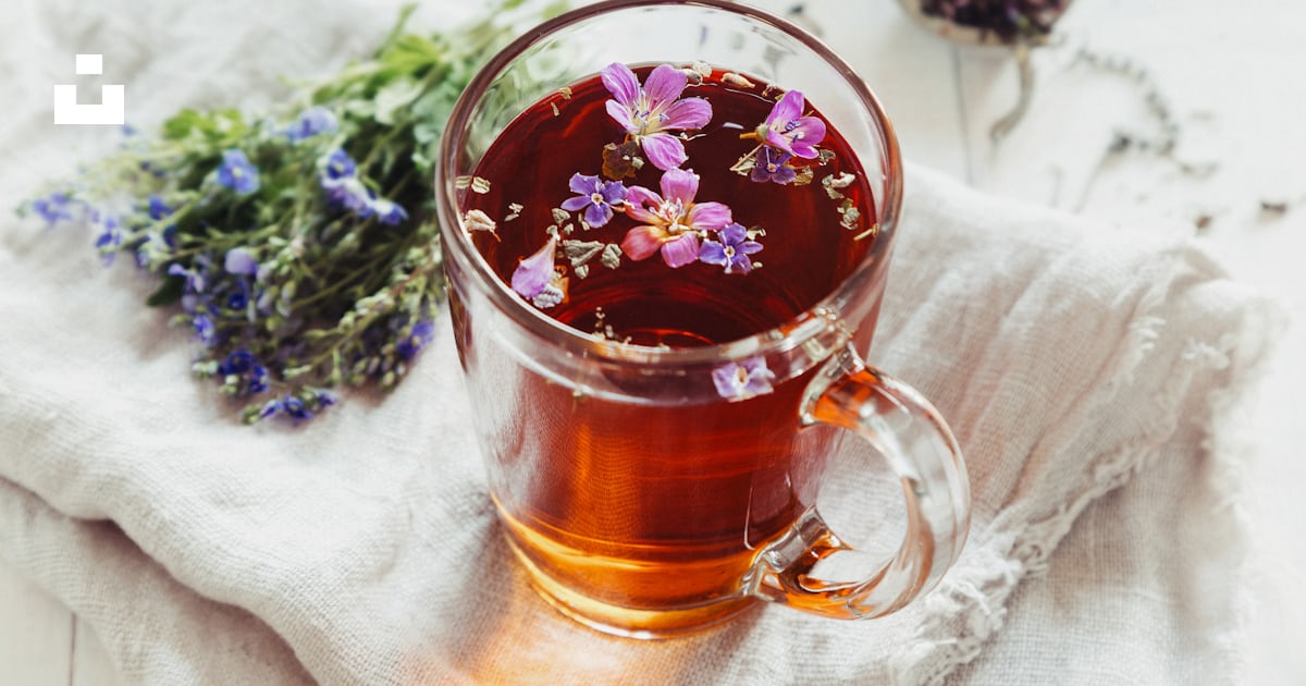 Une Tasse En Verre Remplie De Thé à Côté Dun Bouquet De Fleurs Photo