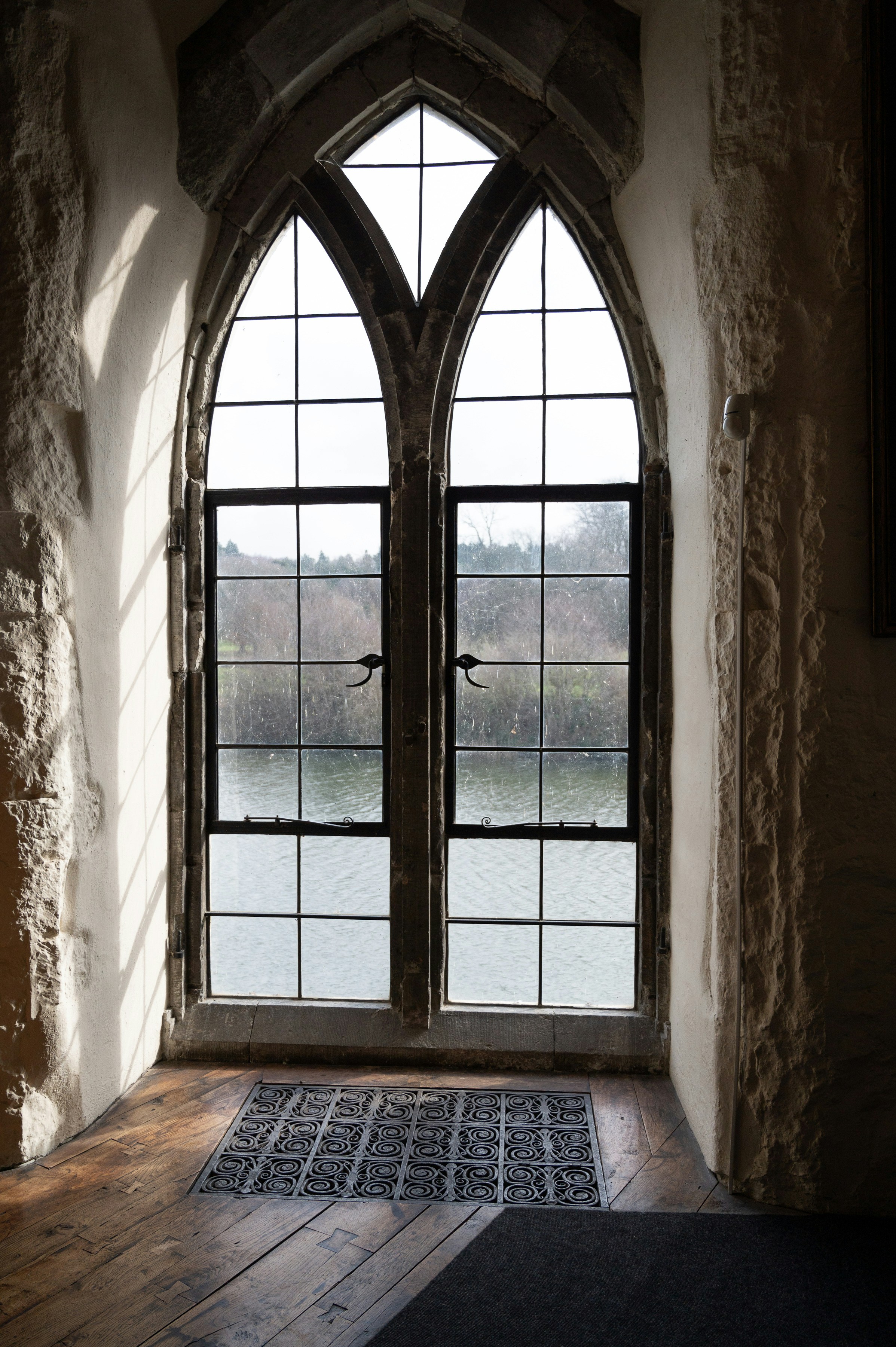 a room with a large window and a rug on the floor