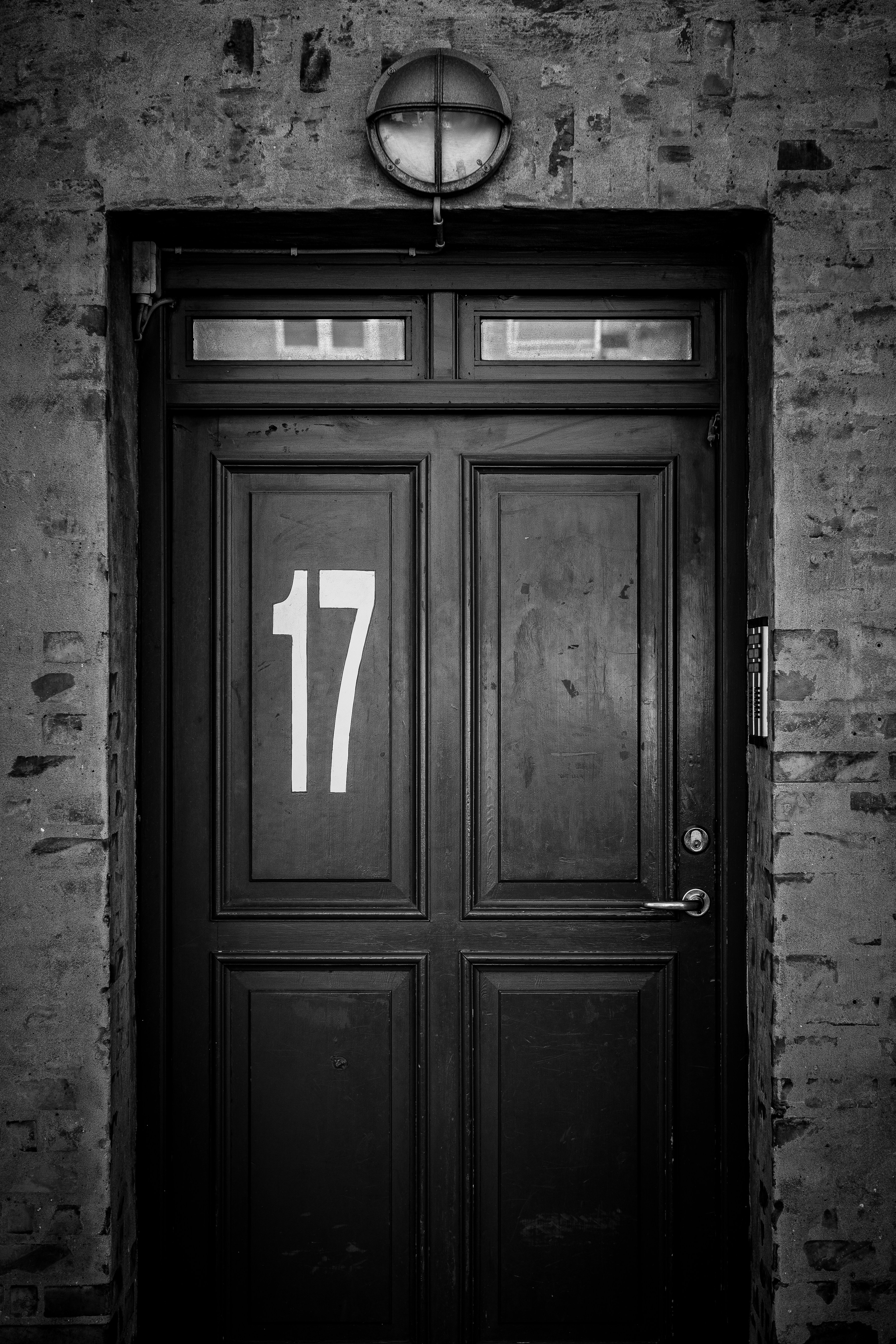 Door 17 in Silent Brickwork: A monochrome doorway under a round lamp