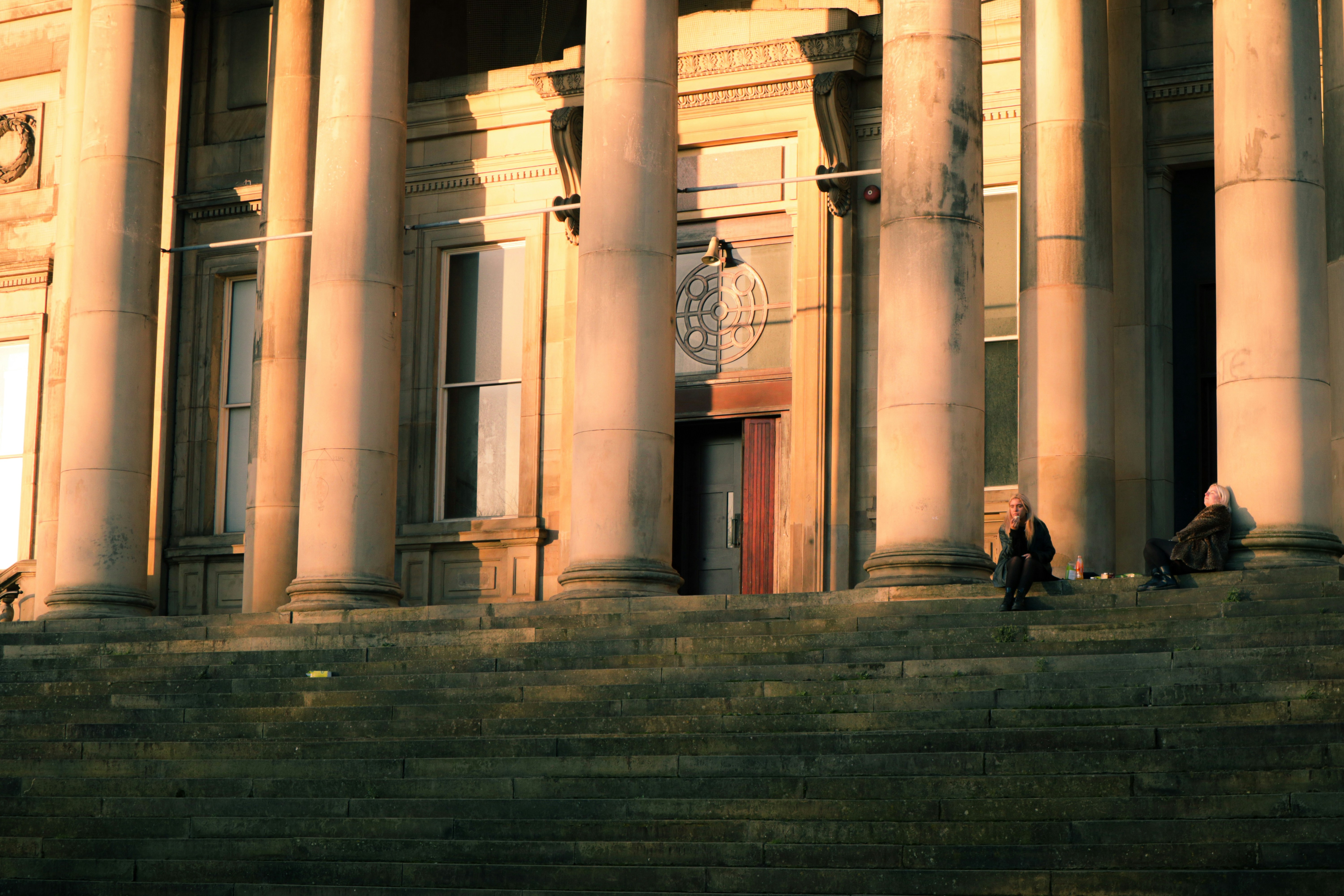 Two people sitting on the steps of a building photo – Free Liverpool ...