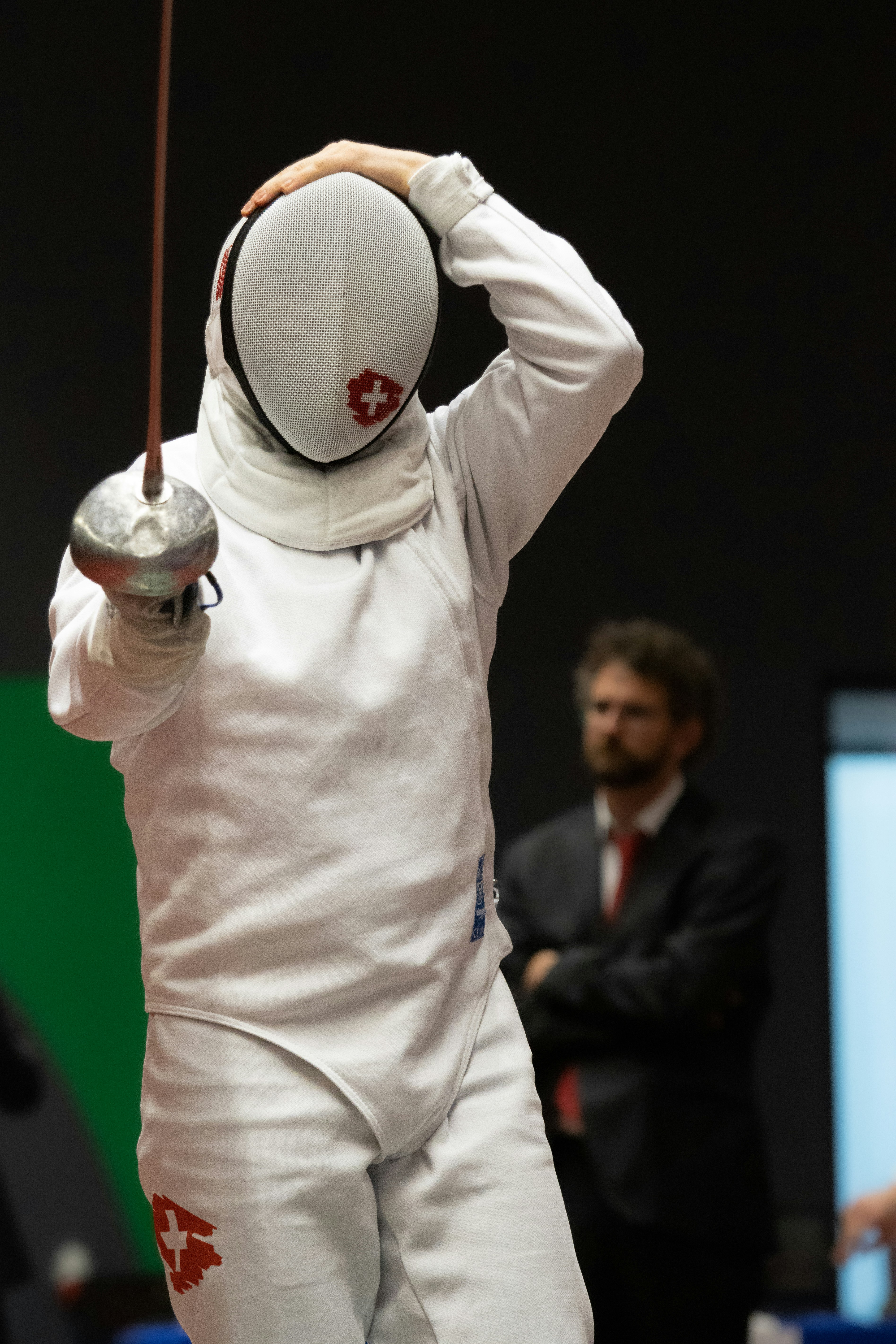 A man in a fencing suit holding a metal object photo – Free Person ...