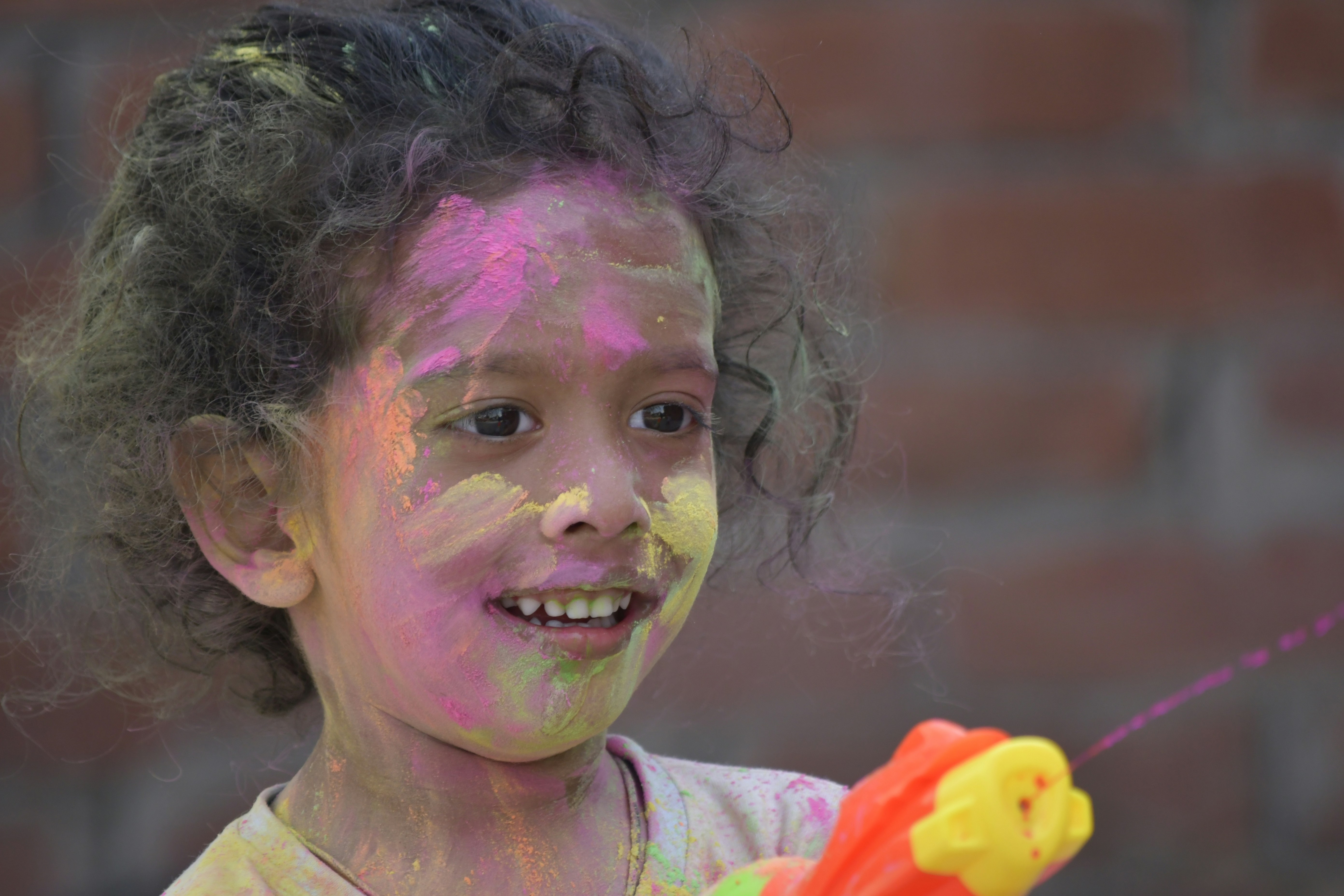 A little girl that is covered in colored powder photo – Free Face Image ...