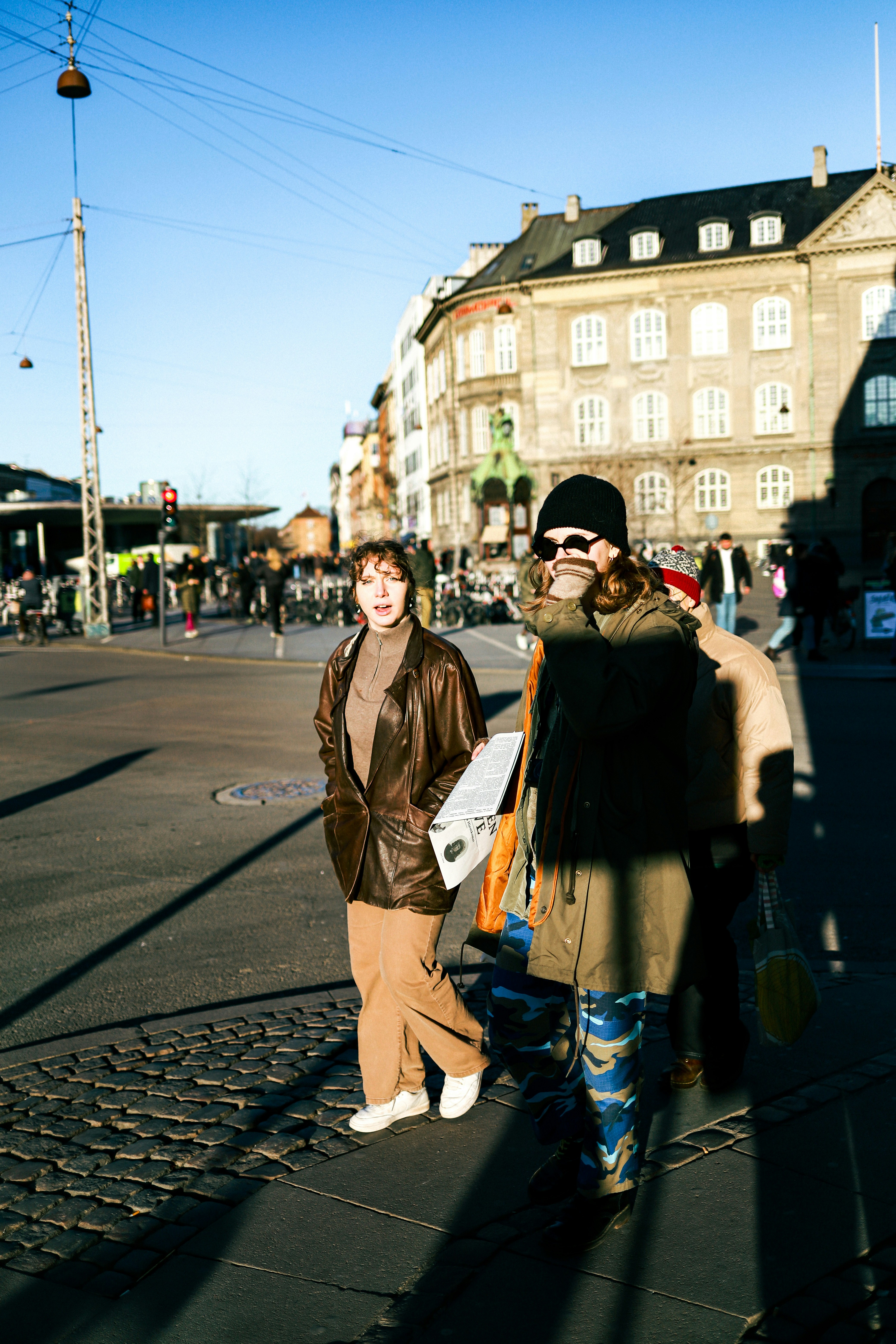 Urban Parade: People Crossing Into a Sunlit City Square