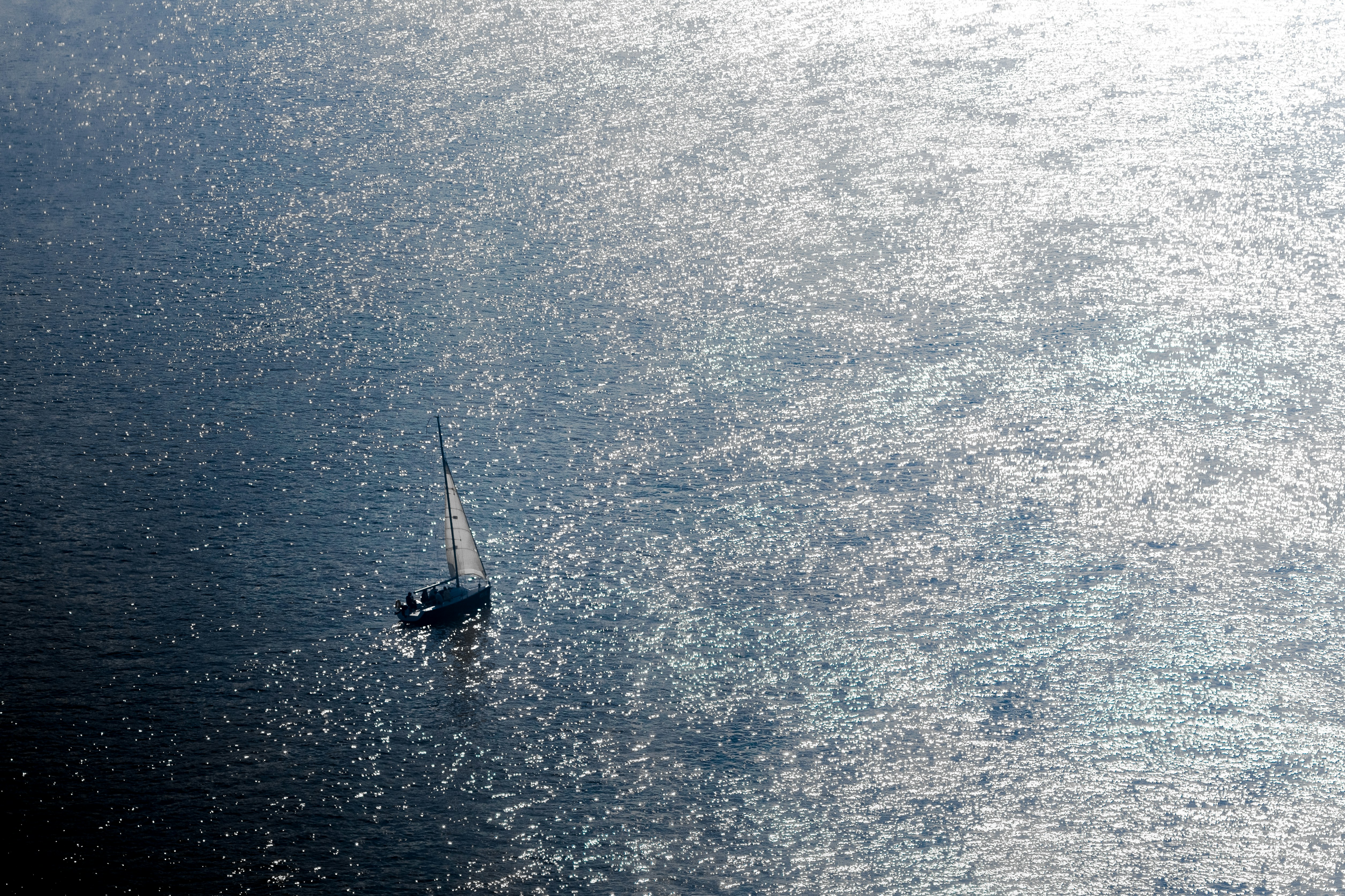 Solitary Sail on Shimmering Waters