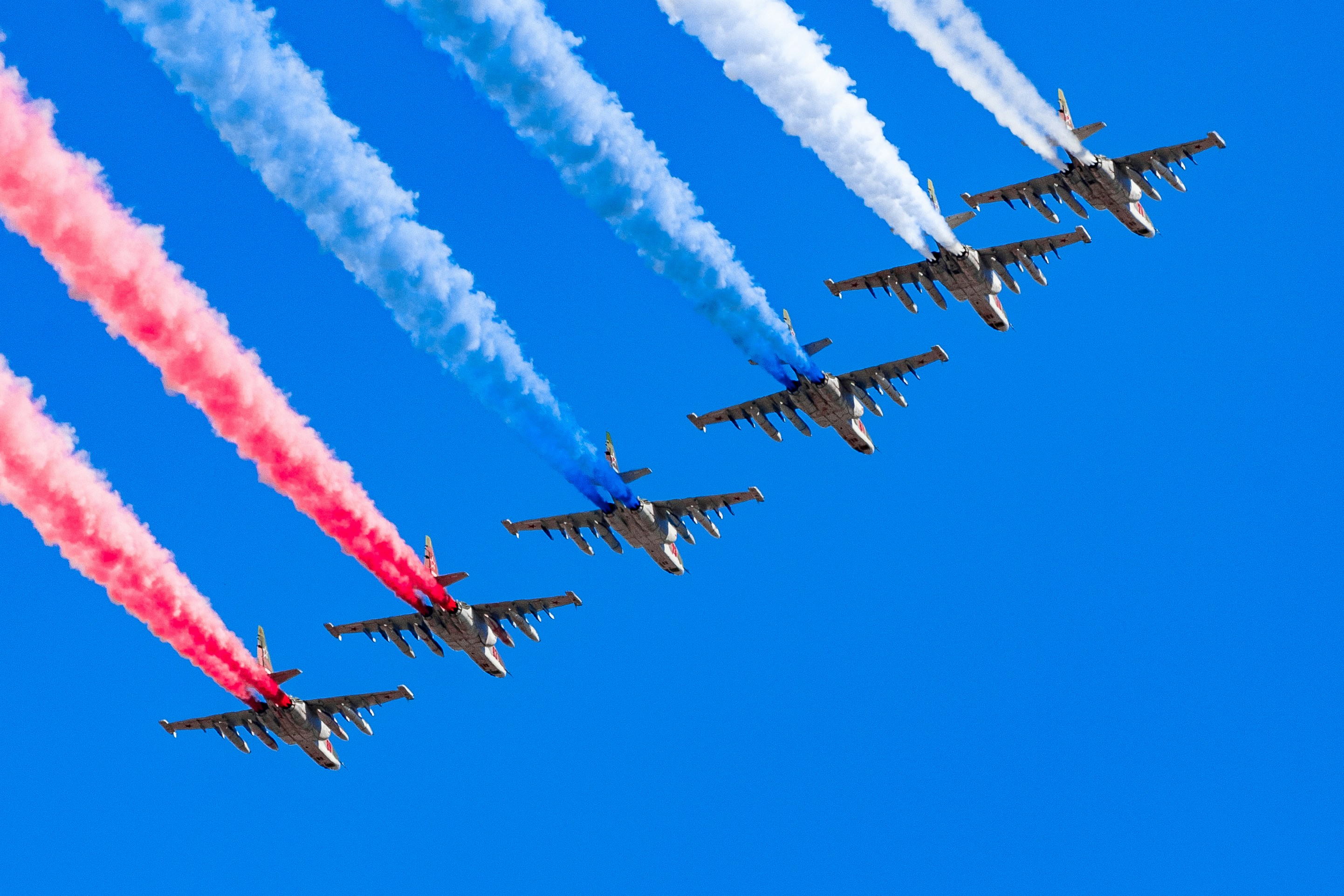 Un grupo de aviones volando en formación con humo de colores detrás de ...