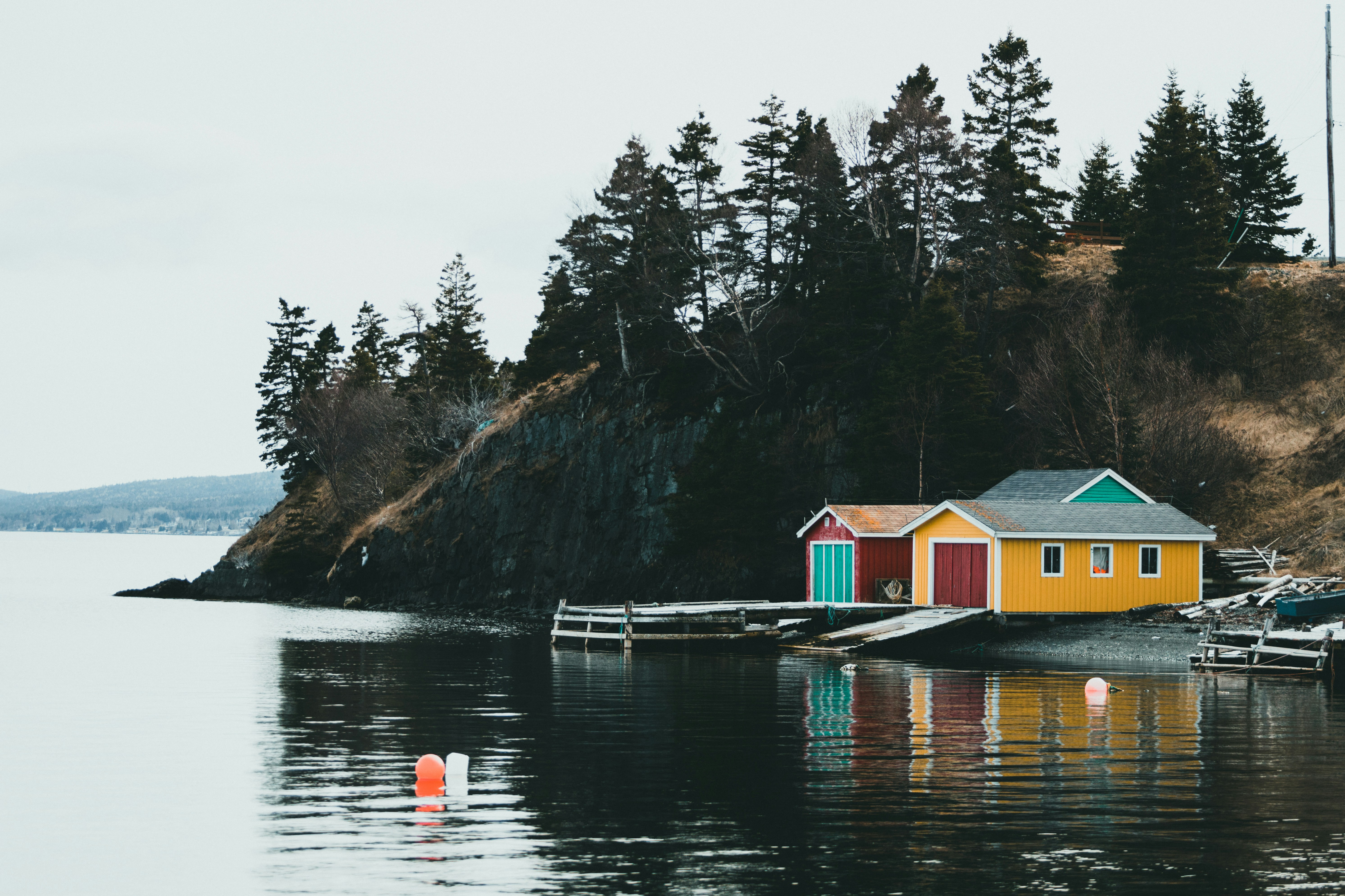 Colorful boathouse cluster at the edge of calm water