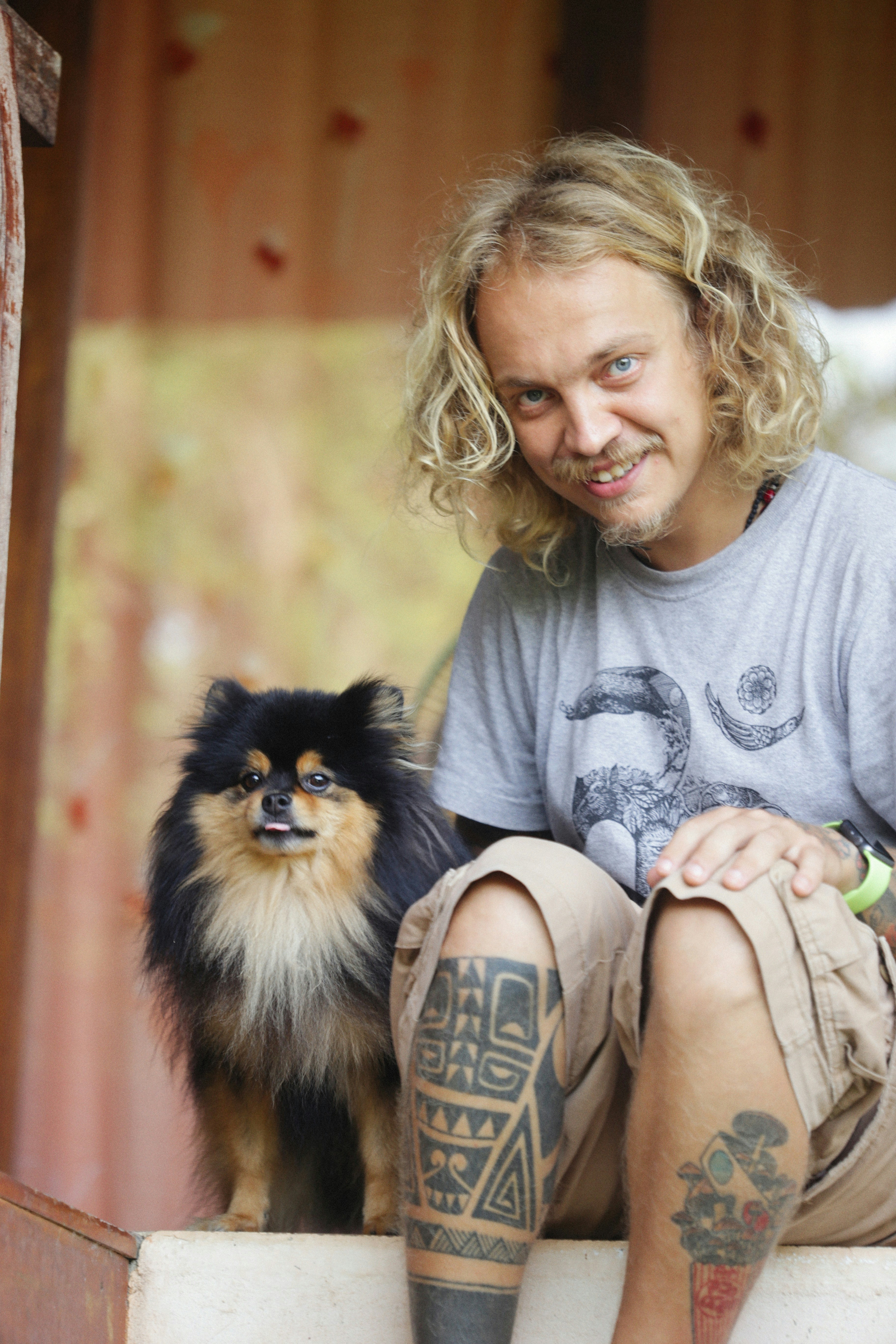 Gentleman with Dreadlocks and Pomeranian on a Sunny Porch