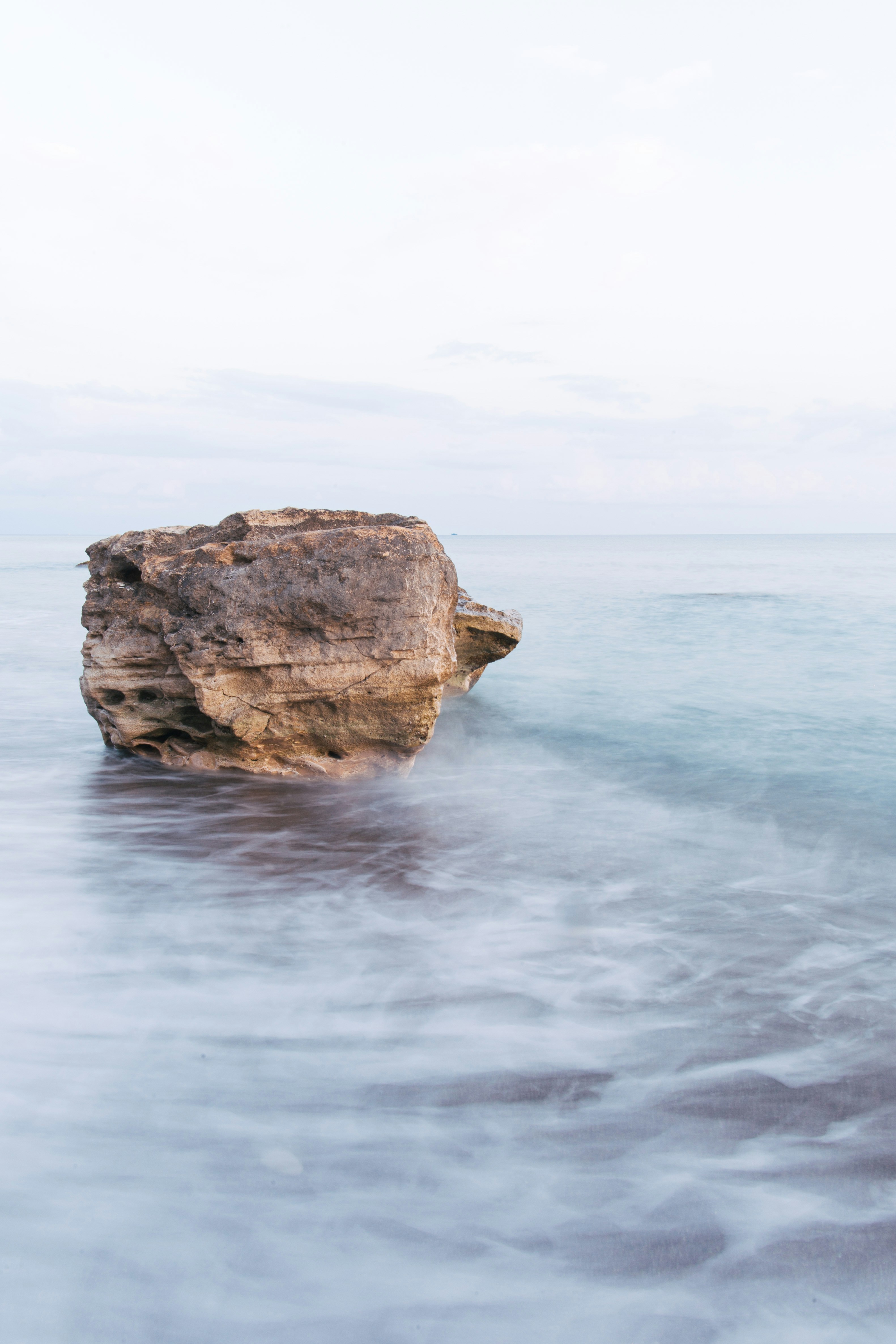 A rock in the water photo – Free Sea Image on Unsplash