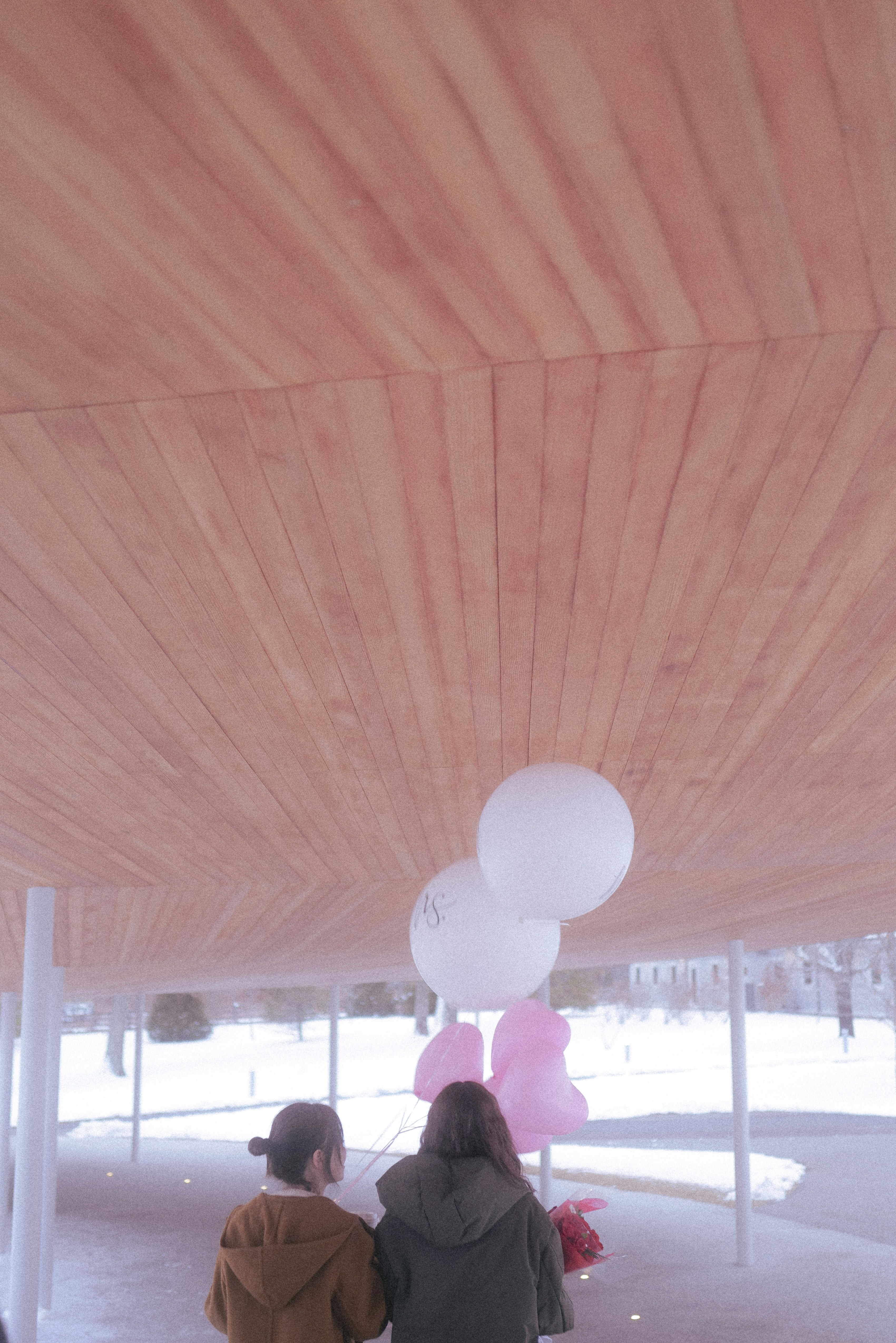 Balloon Moment Beneath a Warm Wooden Canopy in Winter