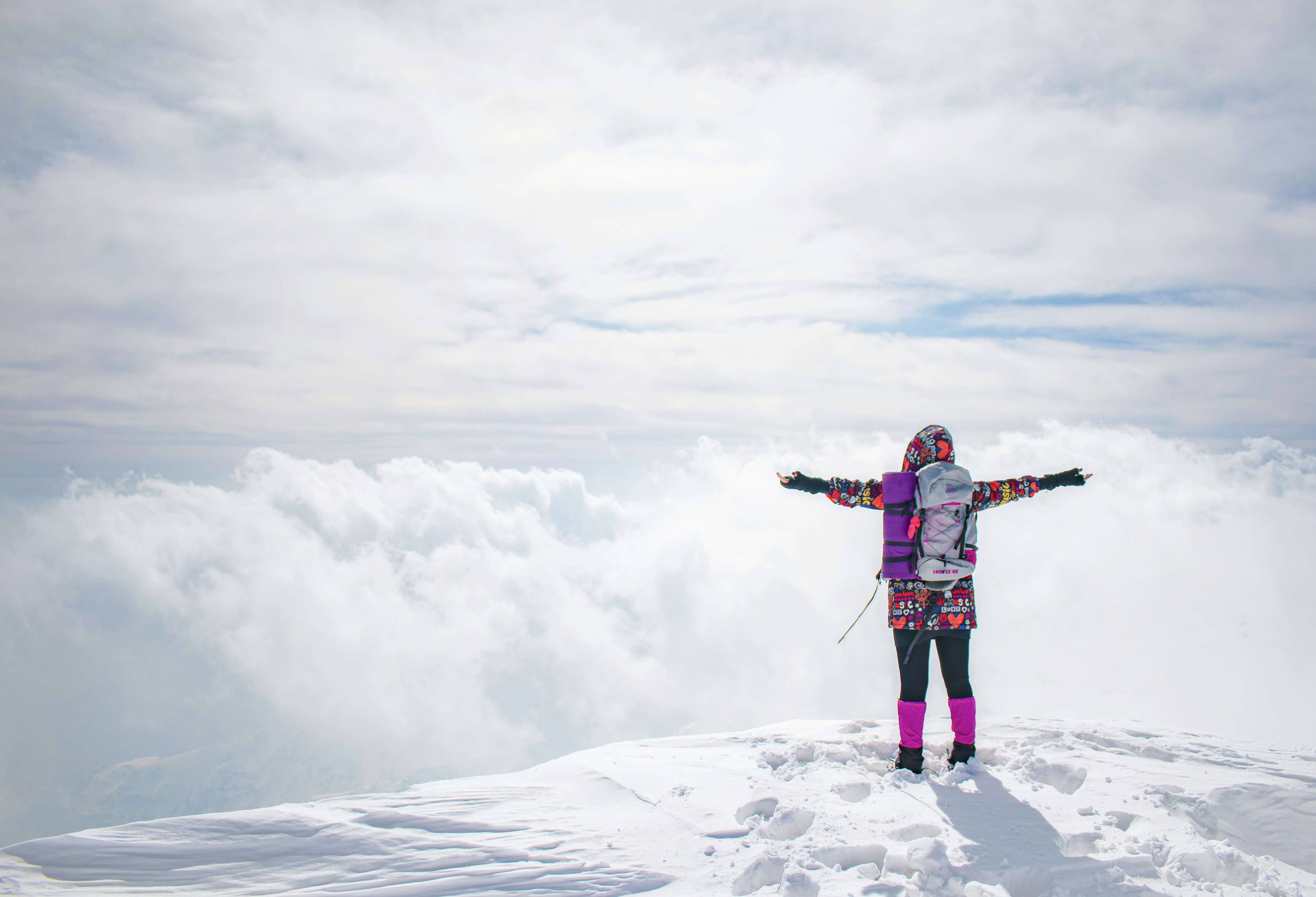 Snowbound Figure with Open Arms on a Cloud-Soft Summit