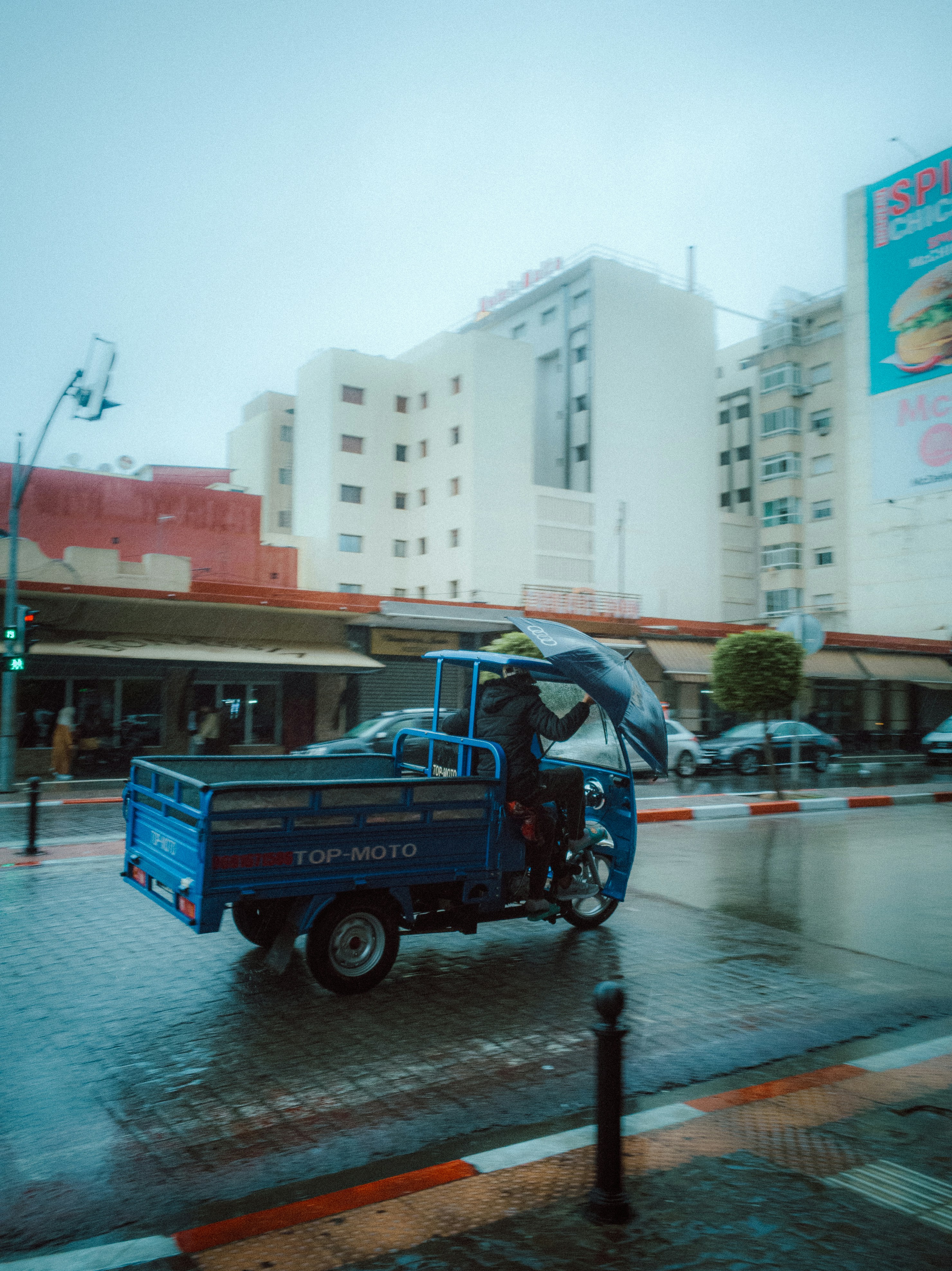 Blue cargo bike in a rainy city street