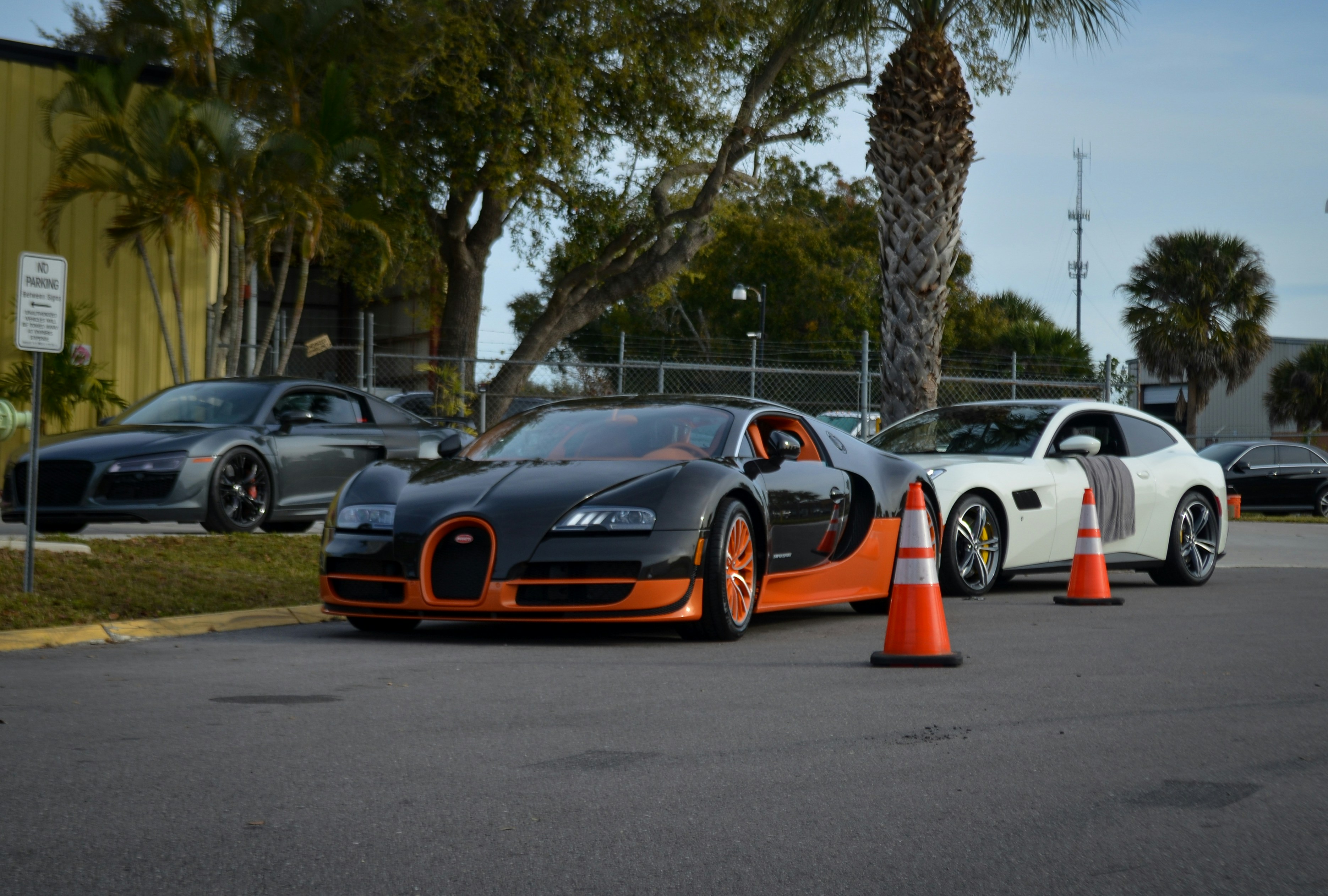 a black sports car parked next to a white car