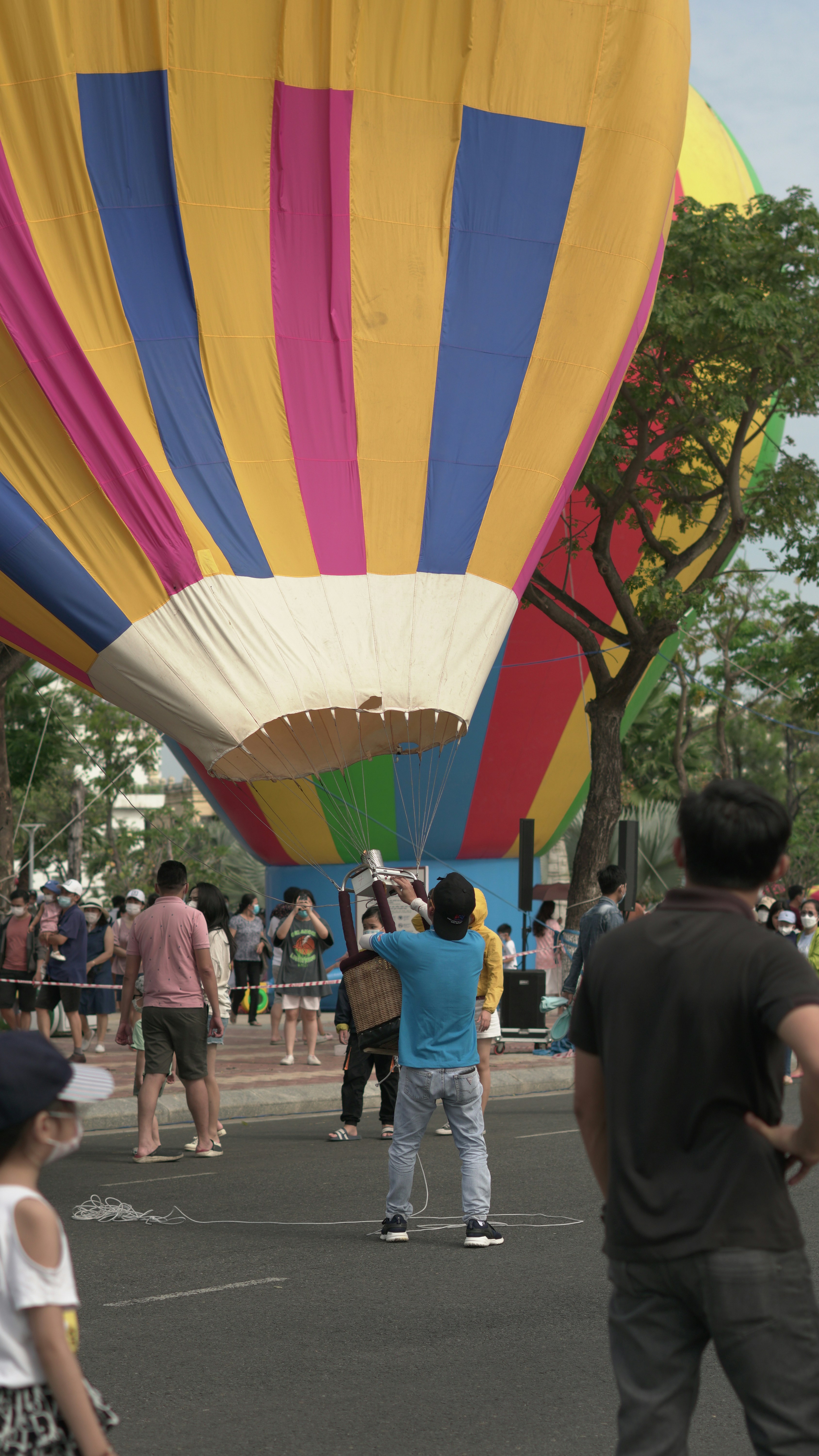 Center of Lift: A Blue-Shirt Handler Guides a Massive Multicolor Balloon