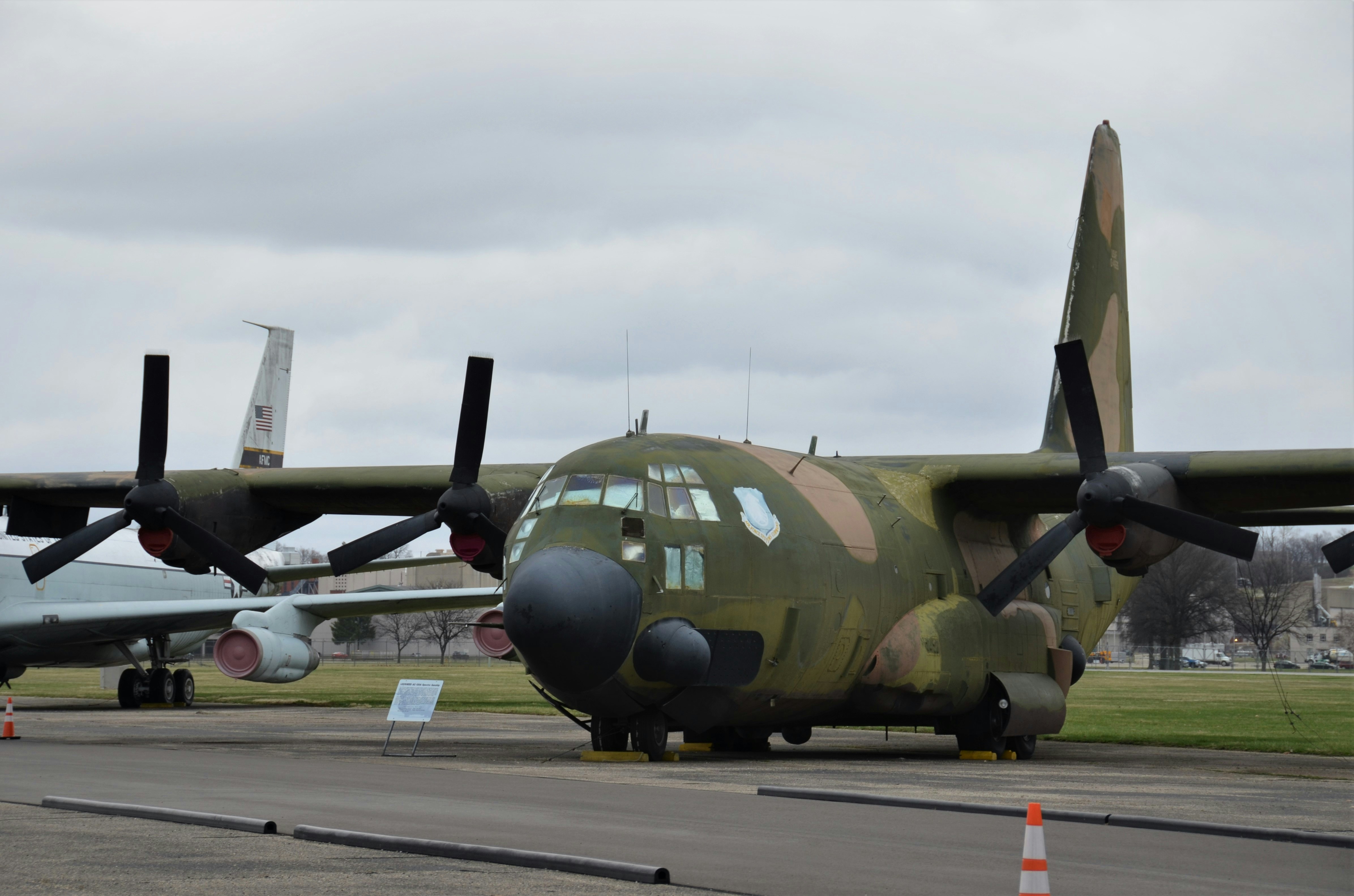 Camouflage on the Apron: Static Military Transport Anchored on a Cloudy Tarmac