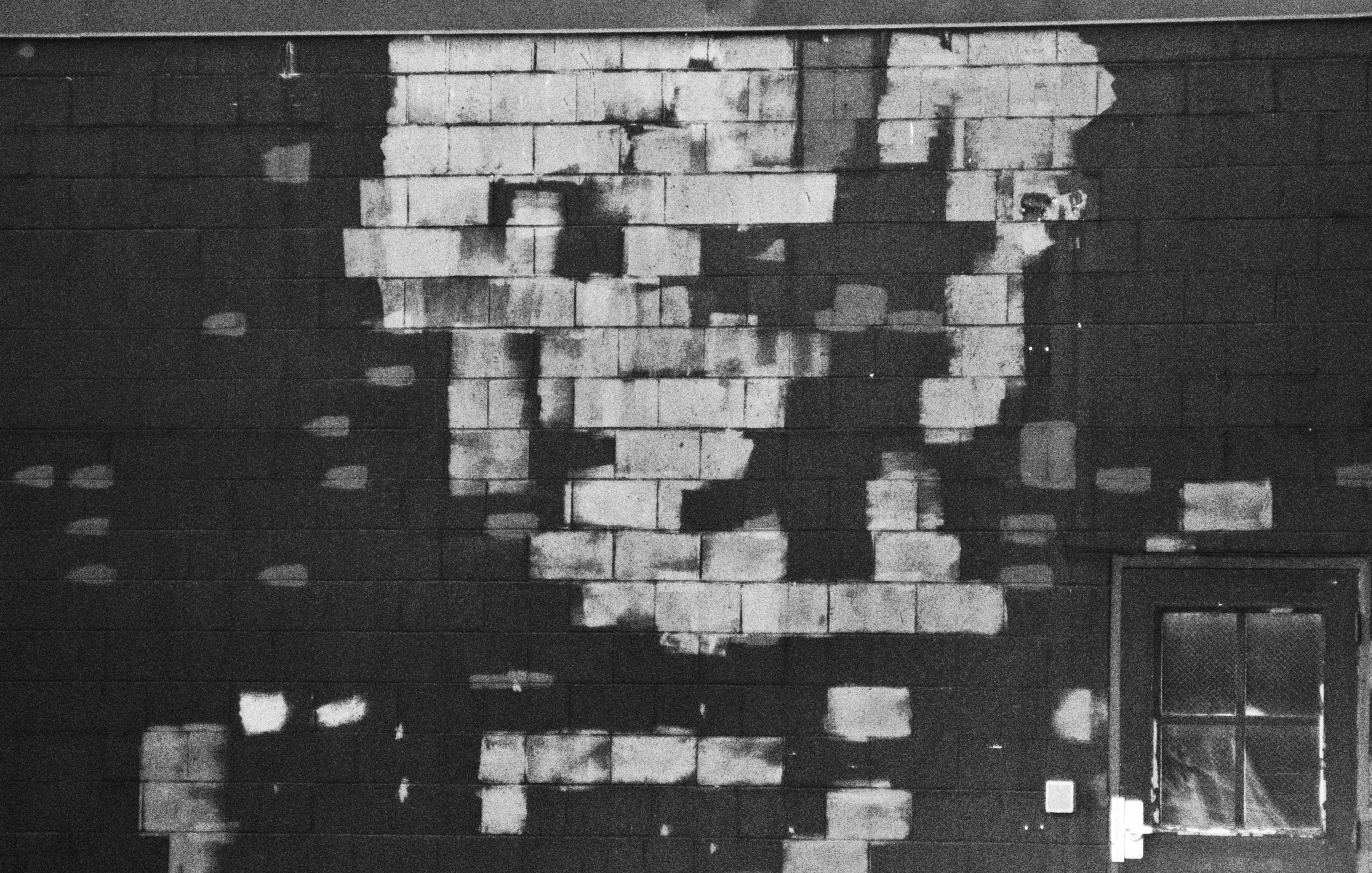 a black and white photo of a brick wall with a hole in it