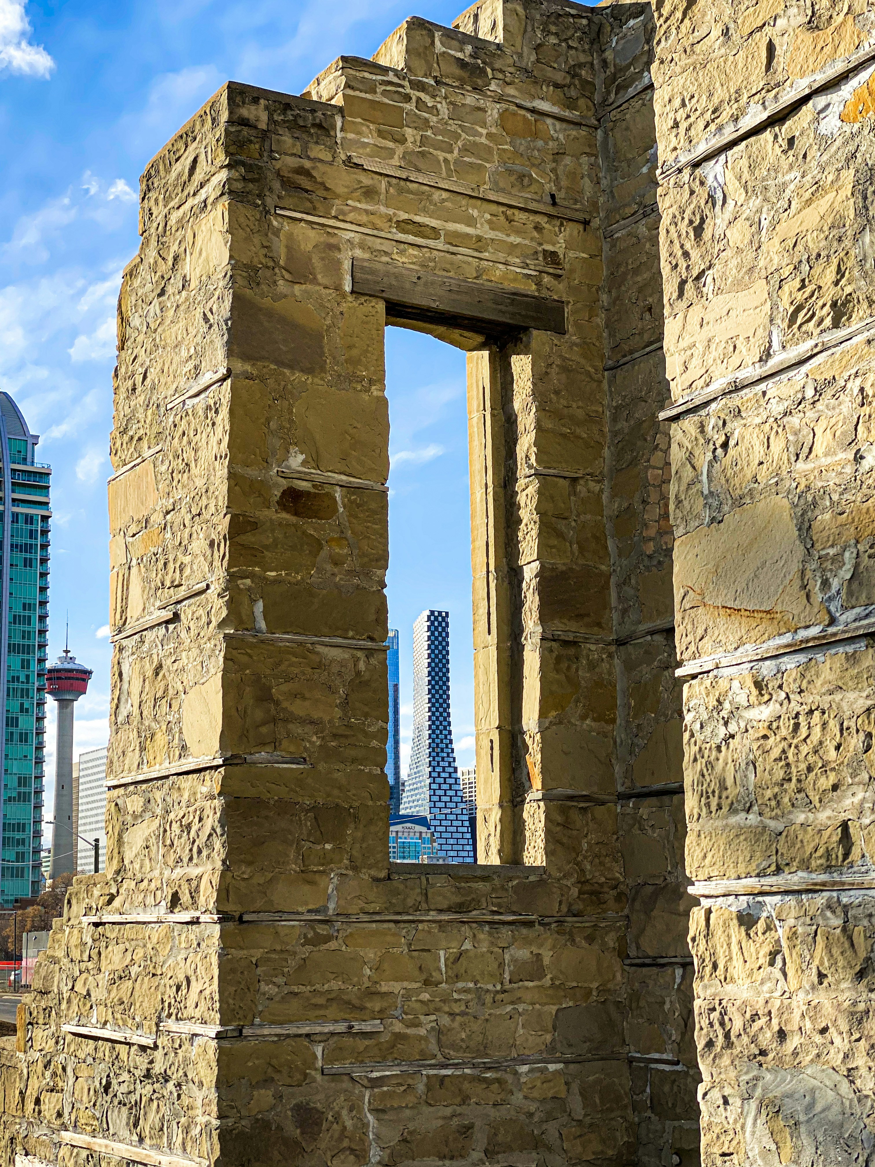 Through the Stone Window: City Spire Framed by Ancient Walls