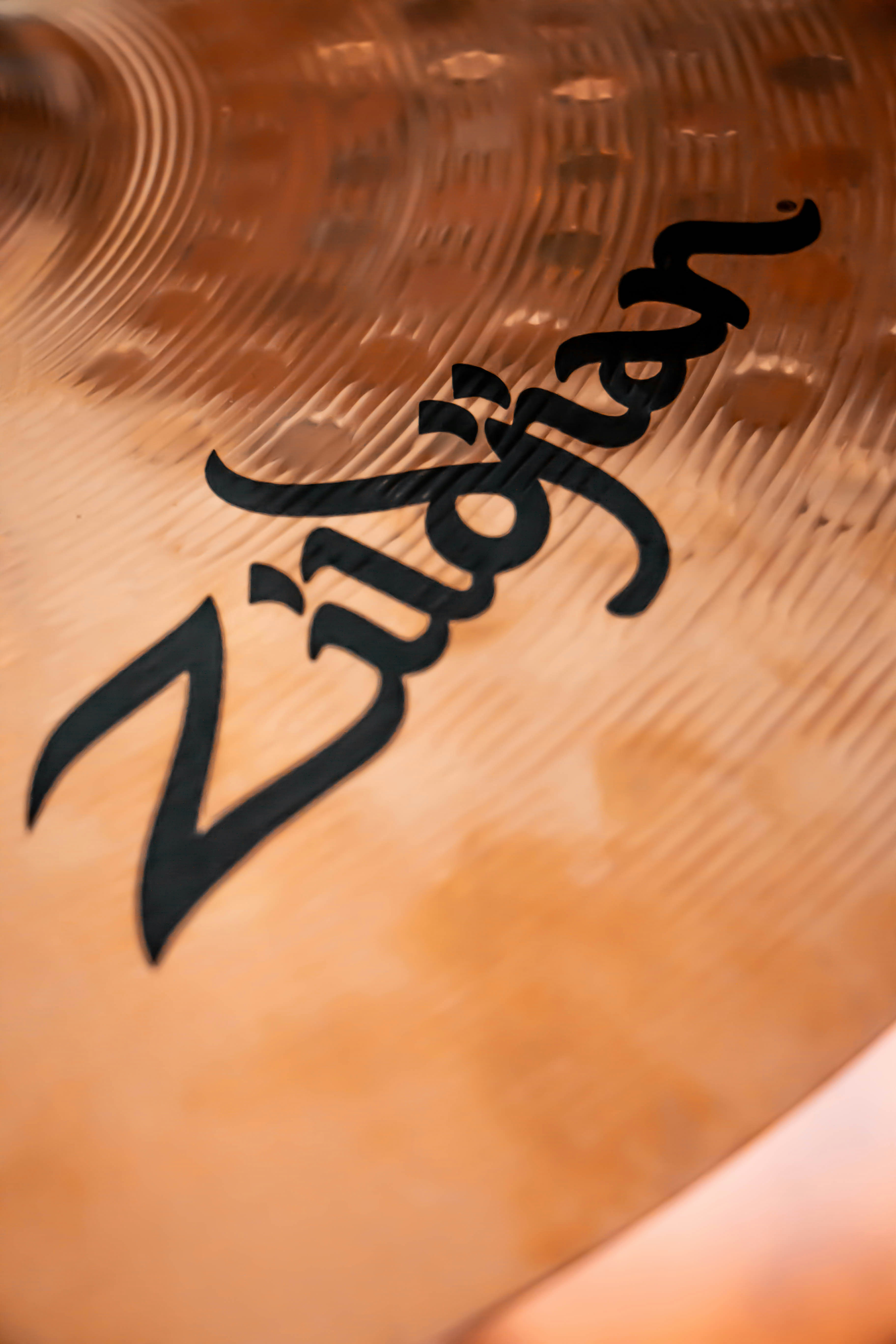 Close-up of a Zildjian cymbal showcasing its intricate texture and elegant logo. The craftsmanship highlights the beauty of musical instruments.