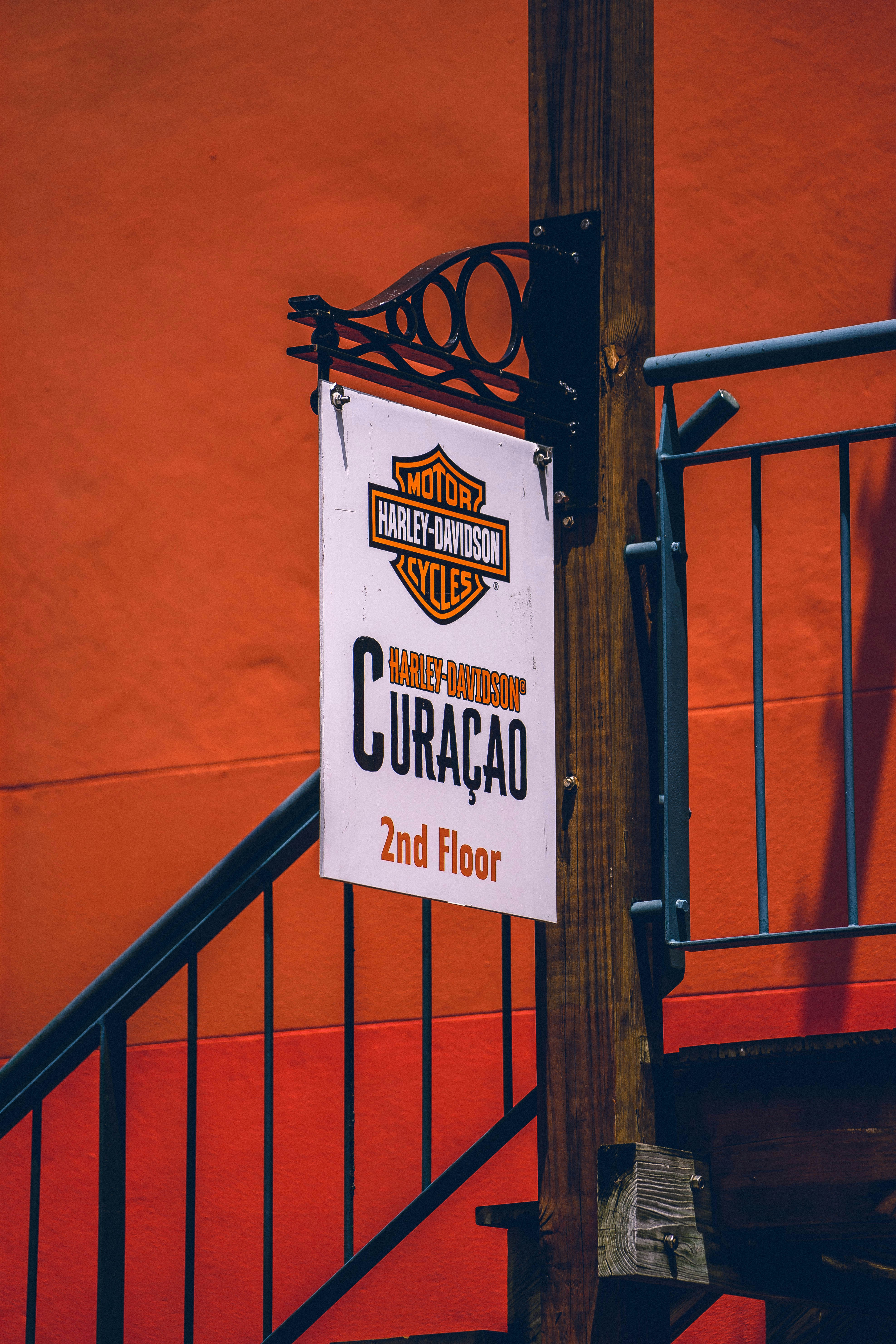 Signage for Harley-Davidson in Curaçao, showcasing the brand's local presence. The bold colors and design emphasize the motorcycle culture.
