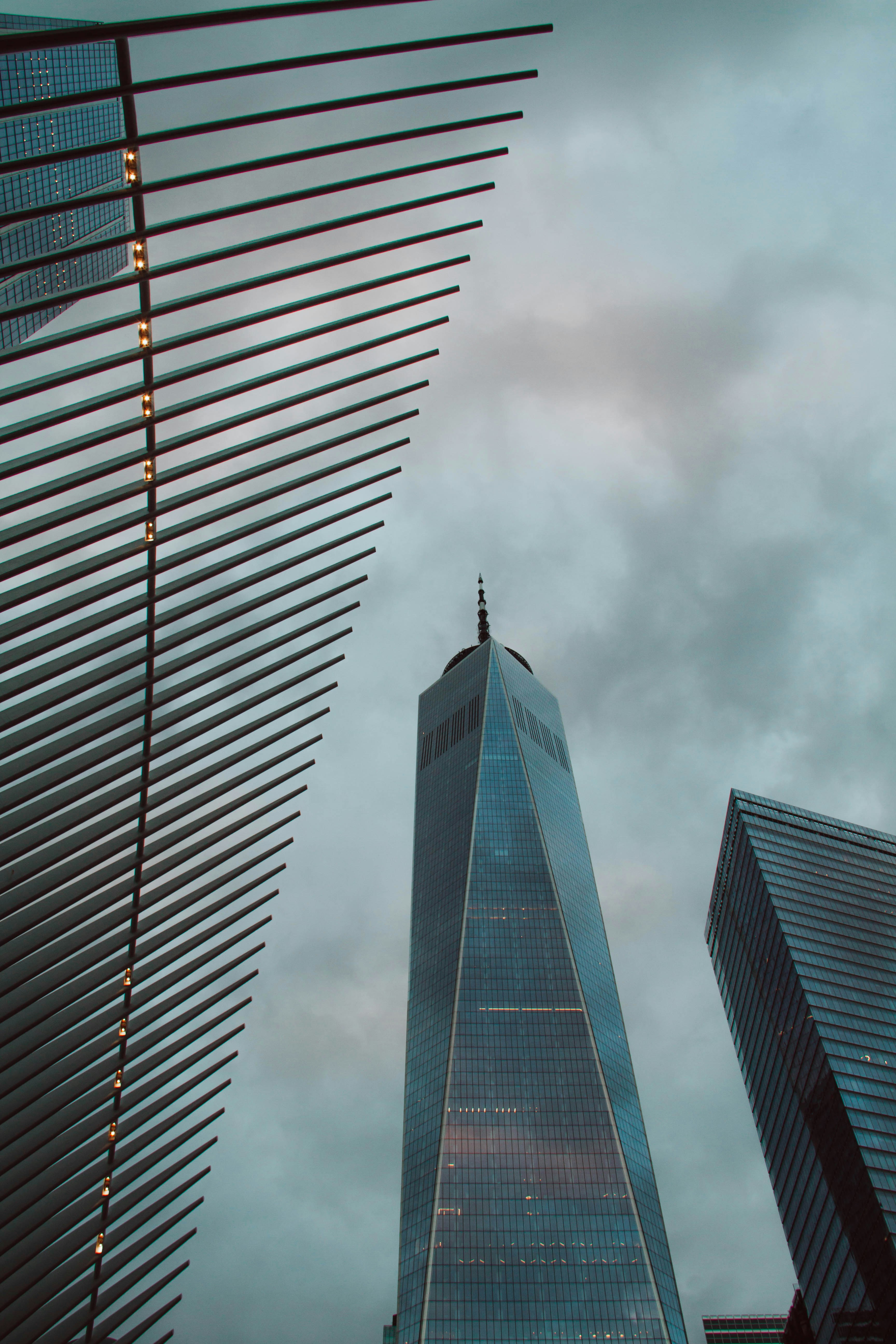 Modern architectural elements converge, showcasing the towering skyscraper against a moody sky.