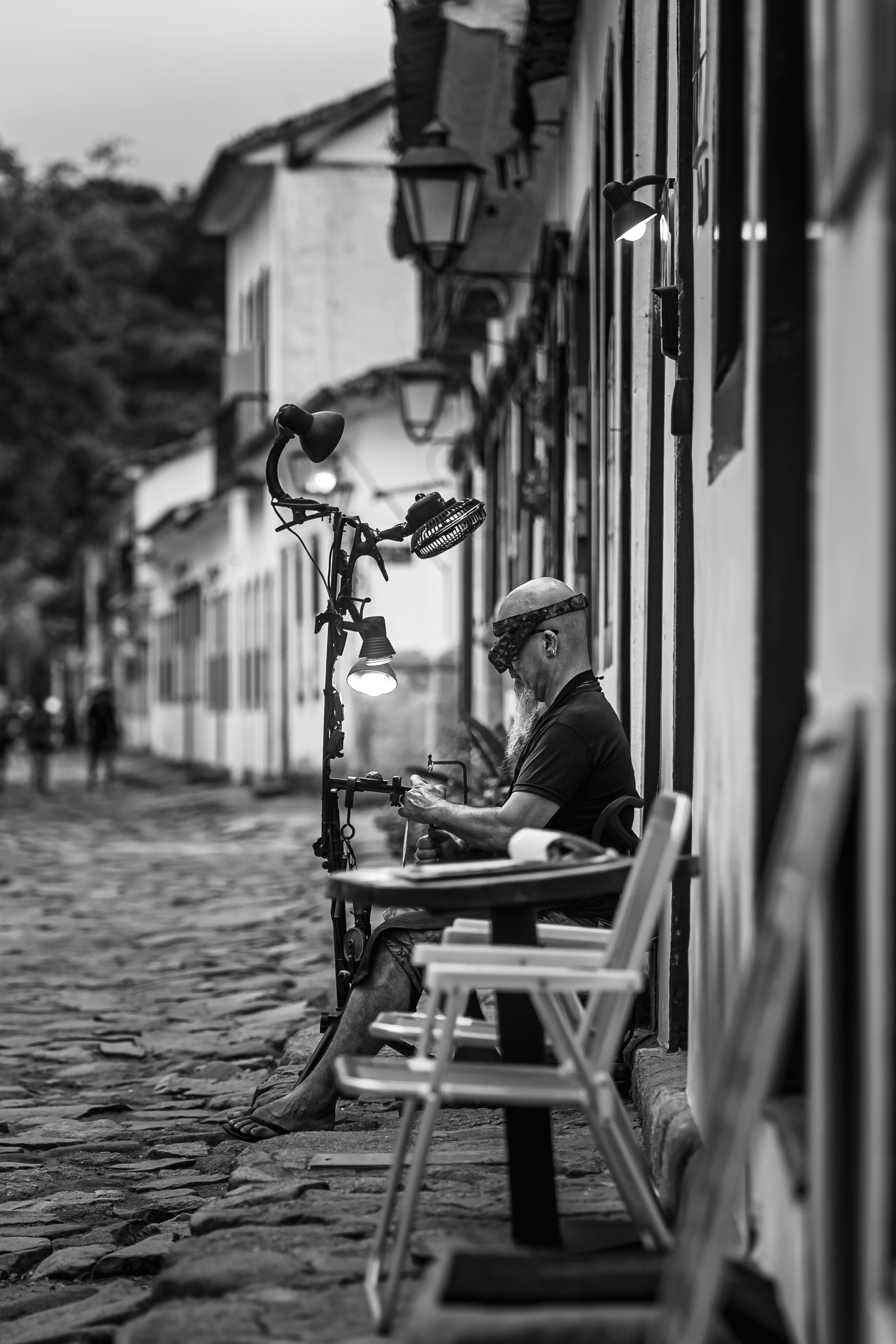 Lamp-lit Solitude: A Man at the Café Beside a Bicycle on a Cobblestone Street