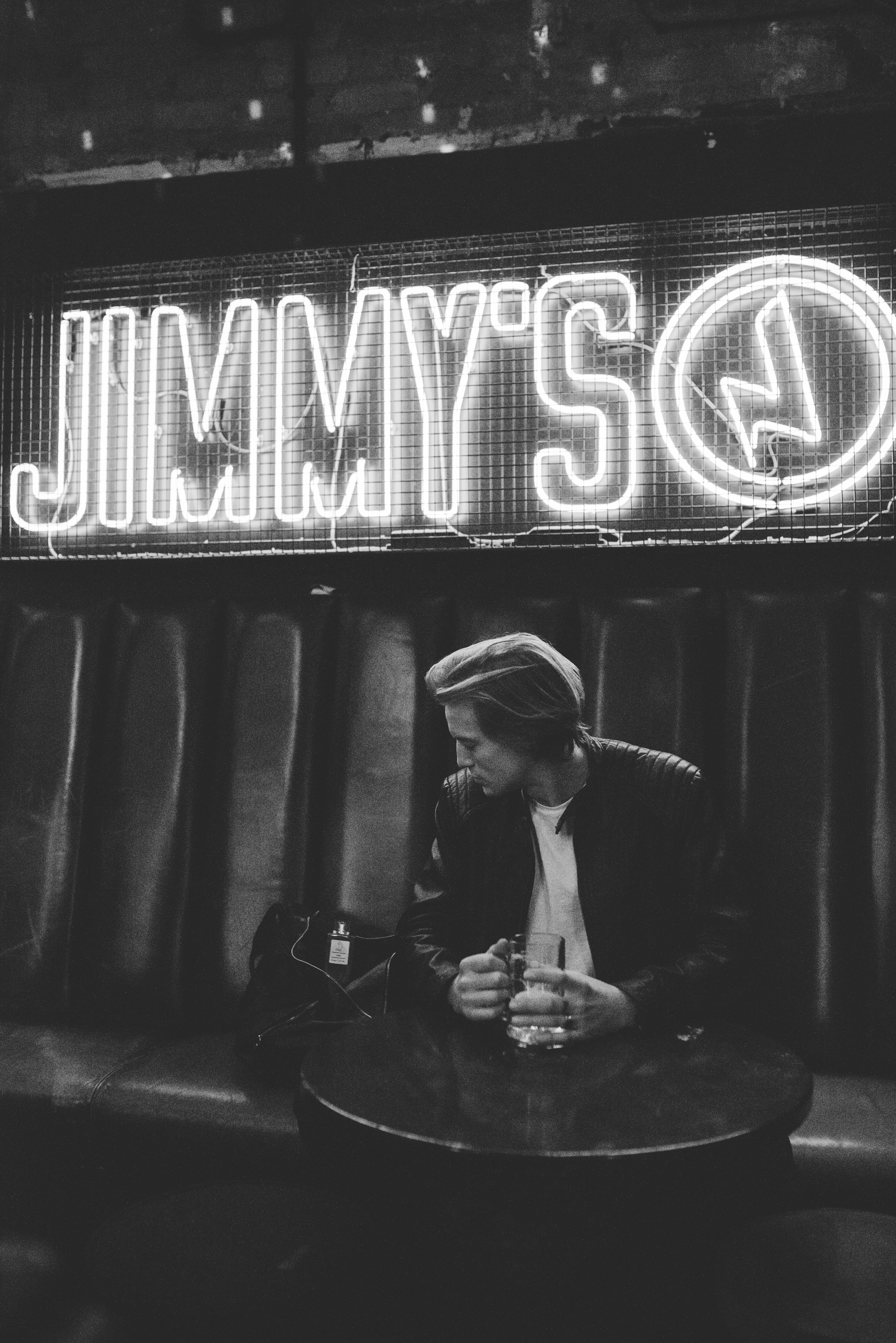 Neon Echo at Jimmy's: A Solitary Moment in Black and White