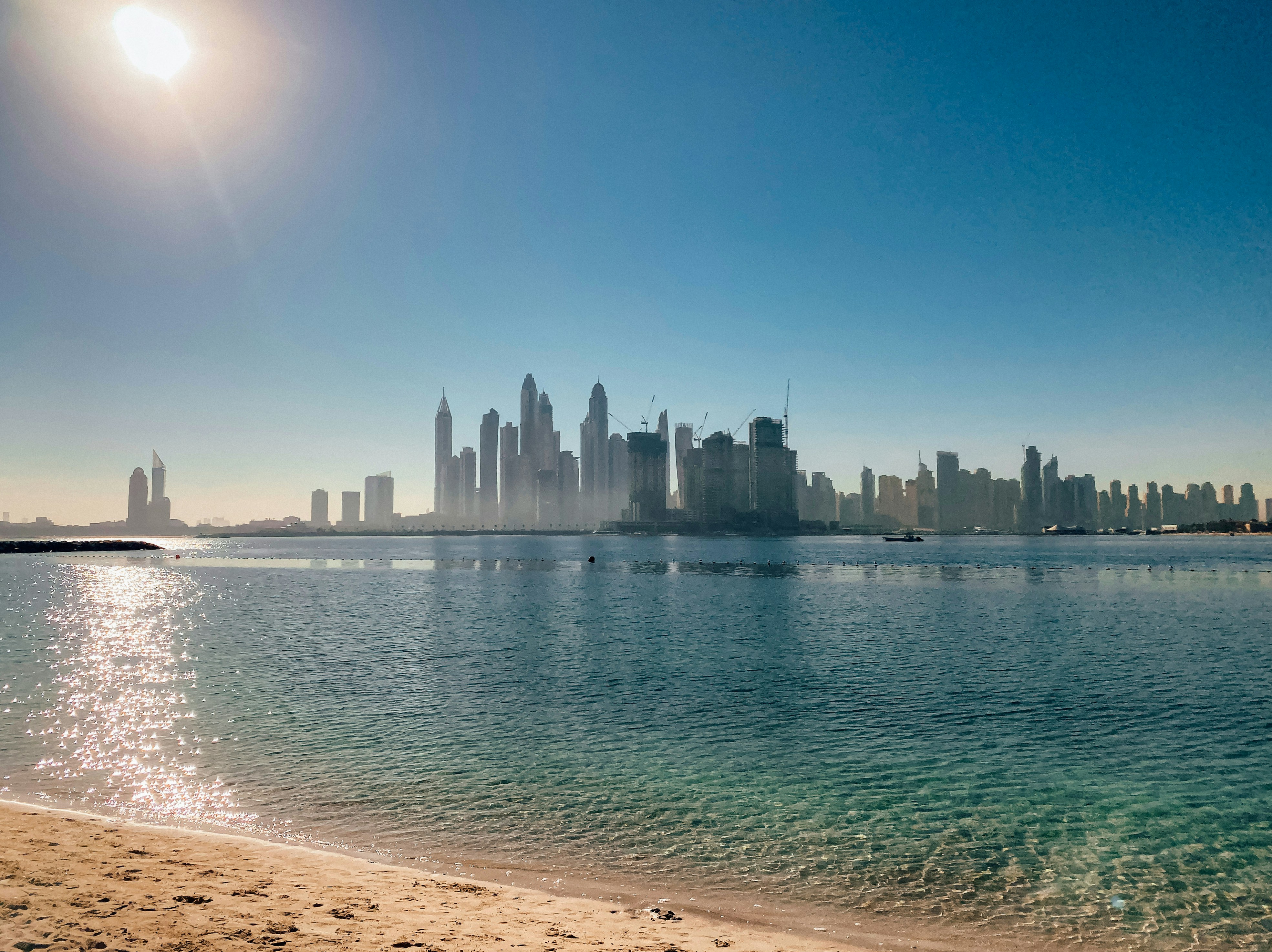 A city skyline across the water photo – Free The palm - jumeirah ...