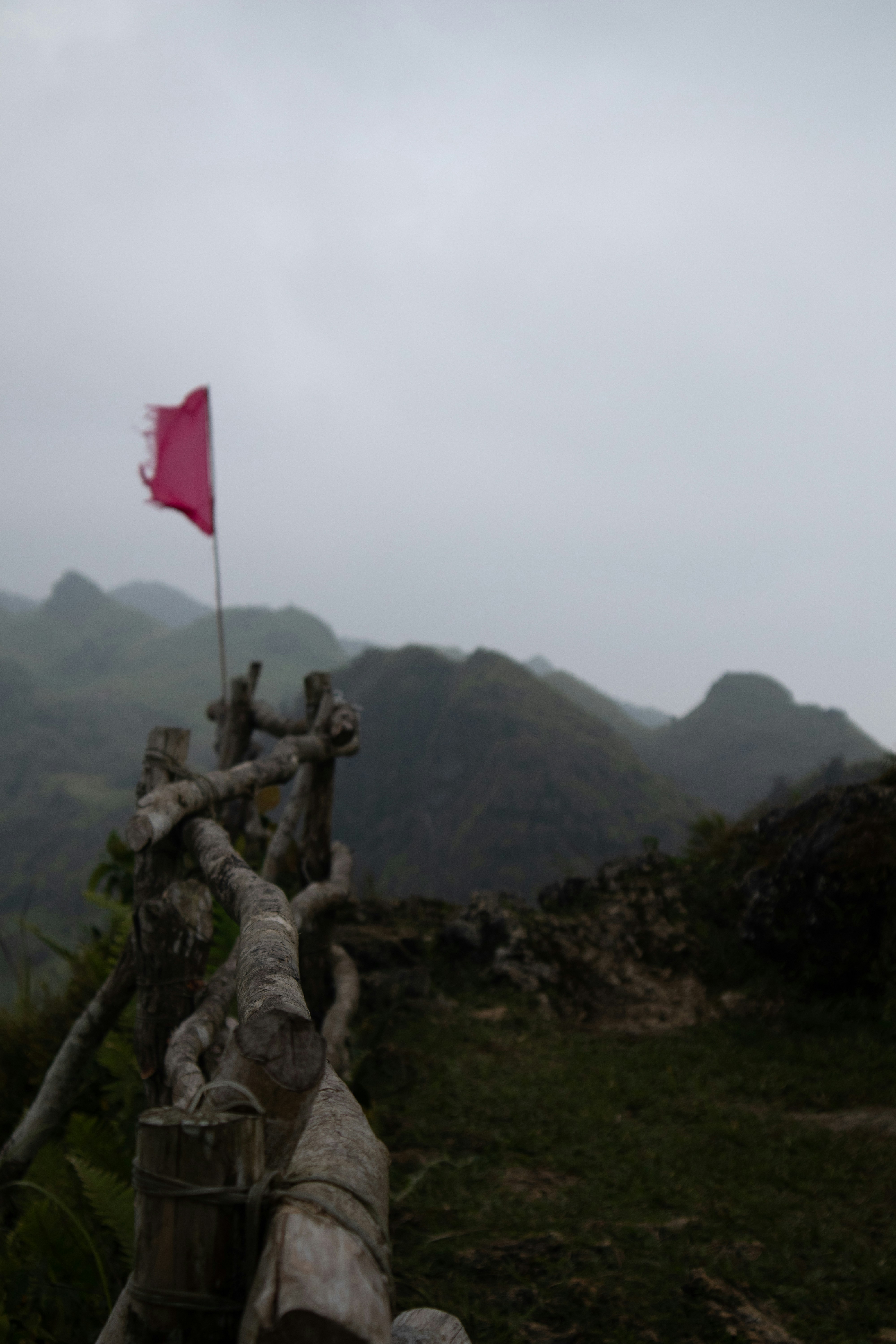 Flag on the Ridge: A Weathered Path Toward the Hidden Peaks