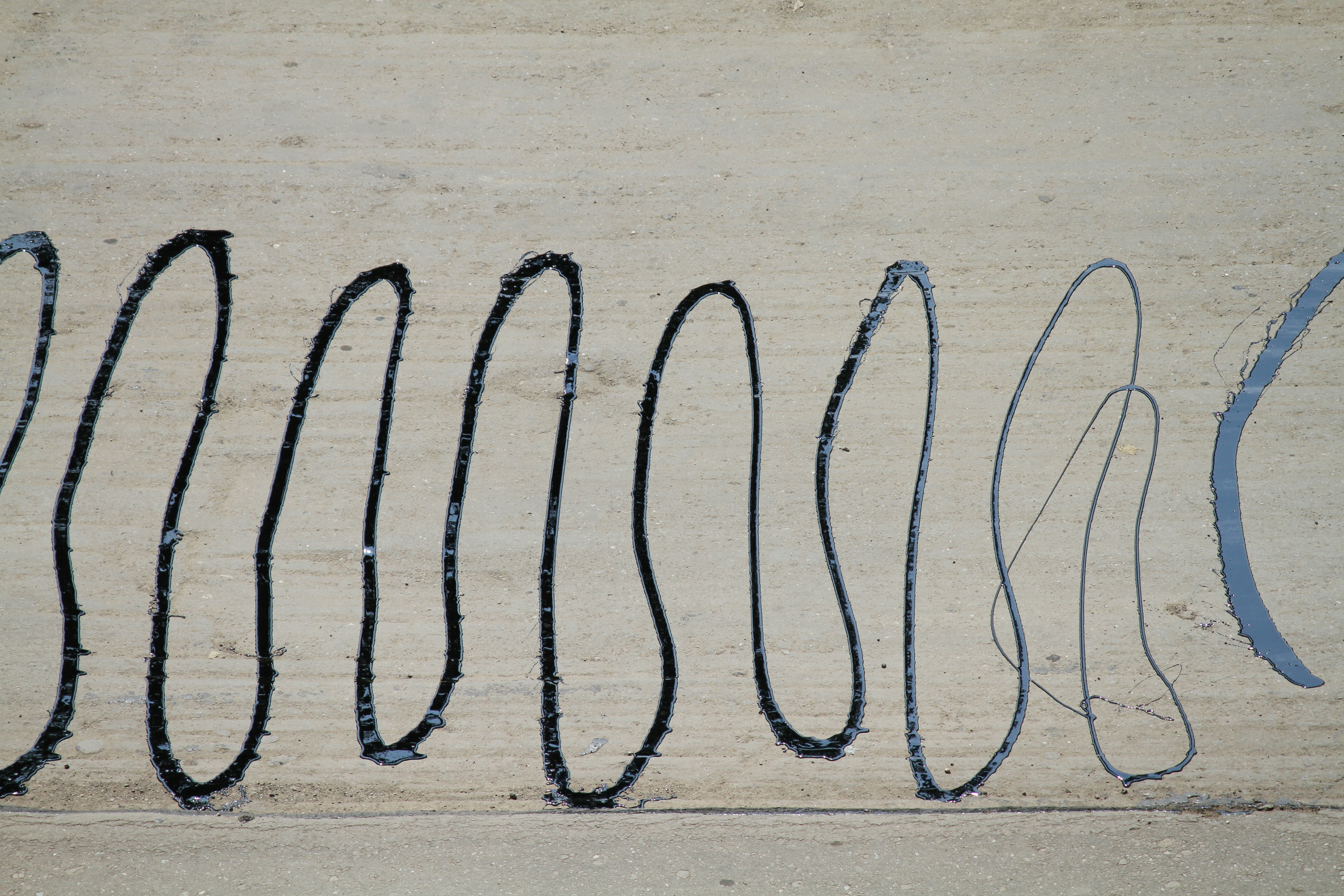 Расплавленный битум на асфальте
 | a close-up of some writing