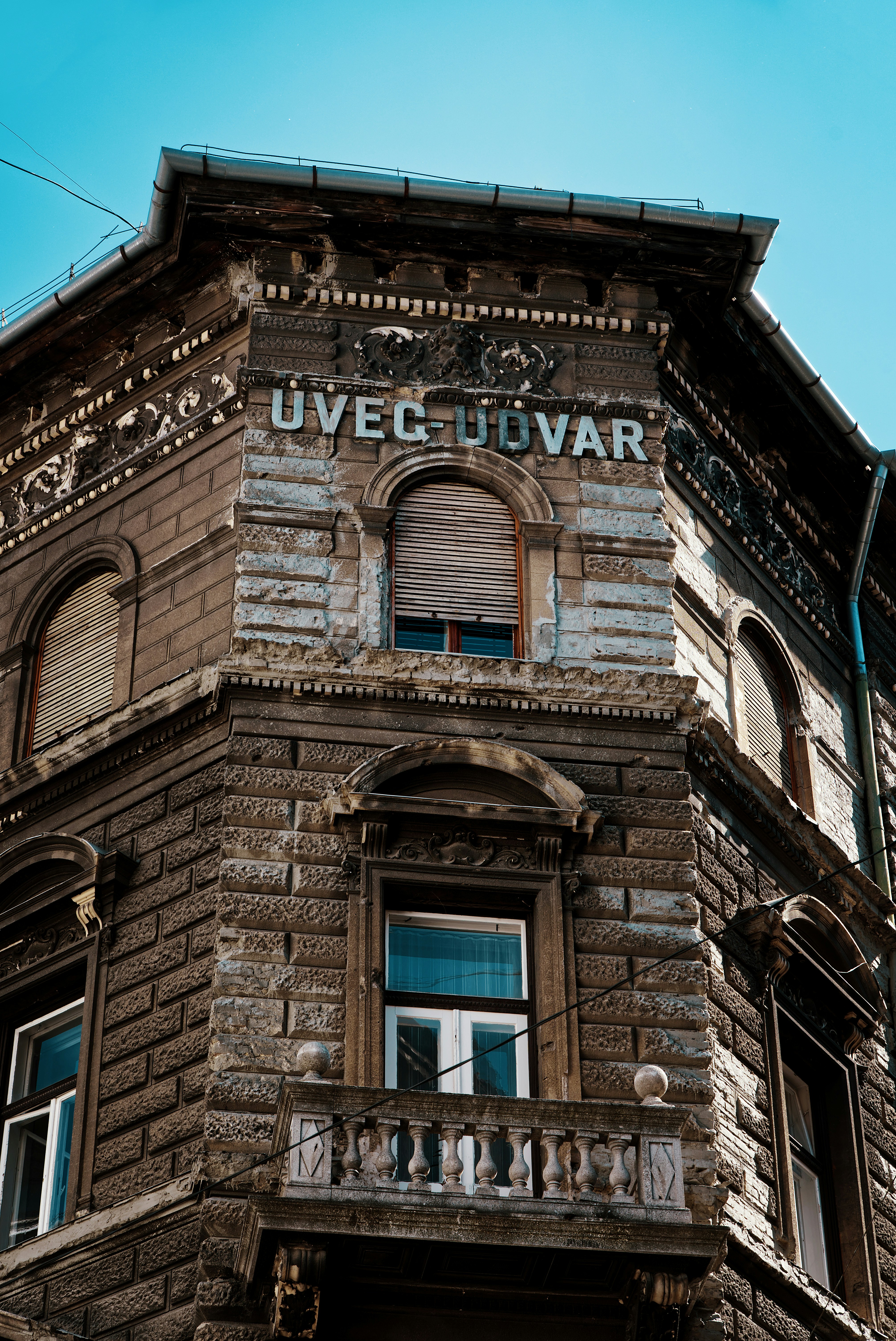 Weathered Cornerstone: Uveck Udvar Facade and Ornate Archway