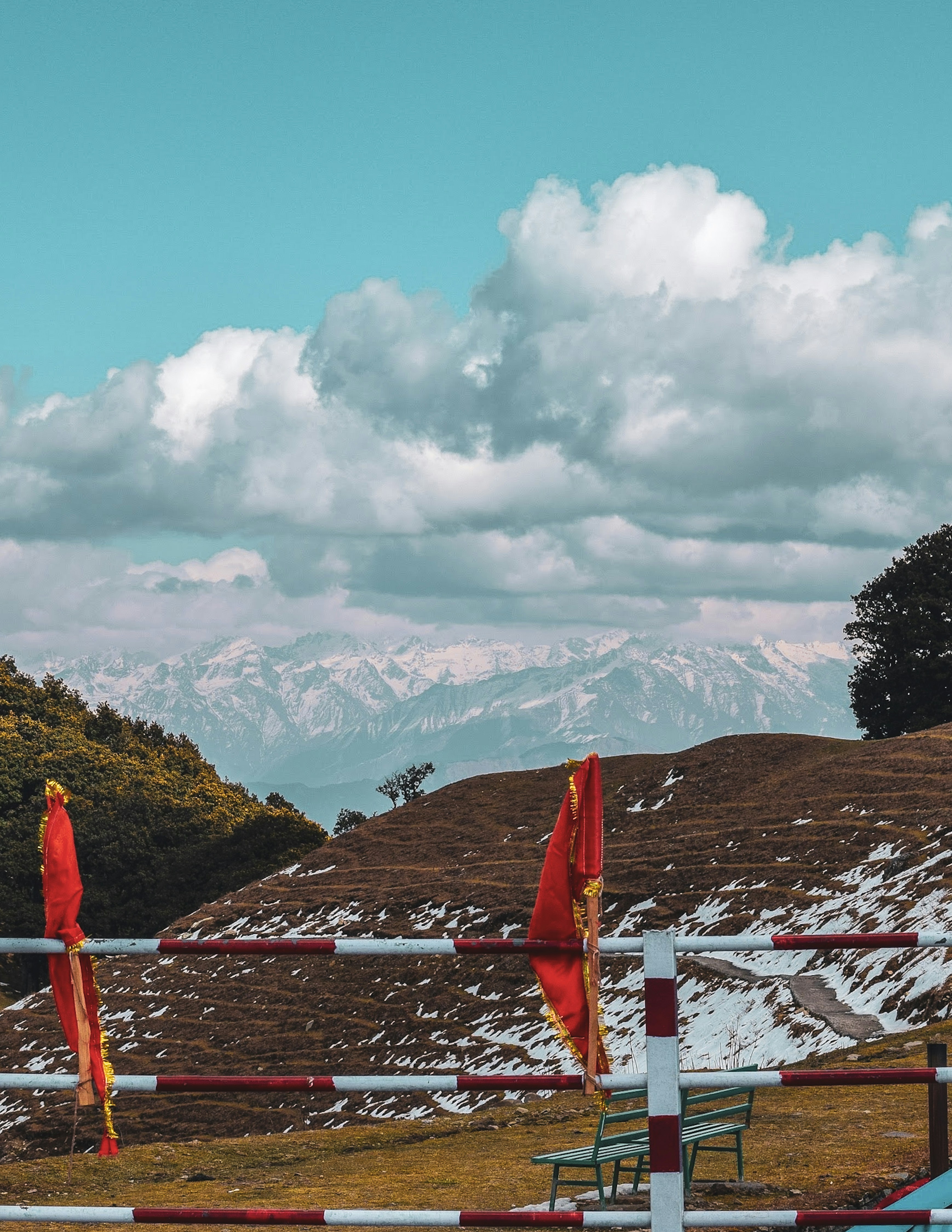 Snow-Kissed Peaks Framed by Red-White Rails on a Quiet Hillside