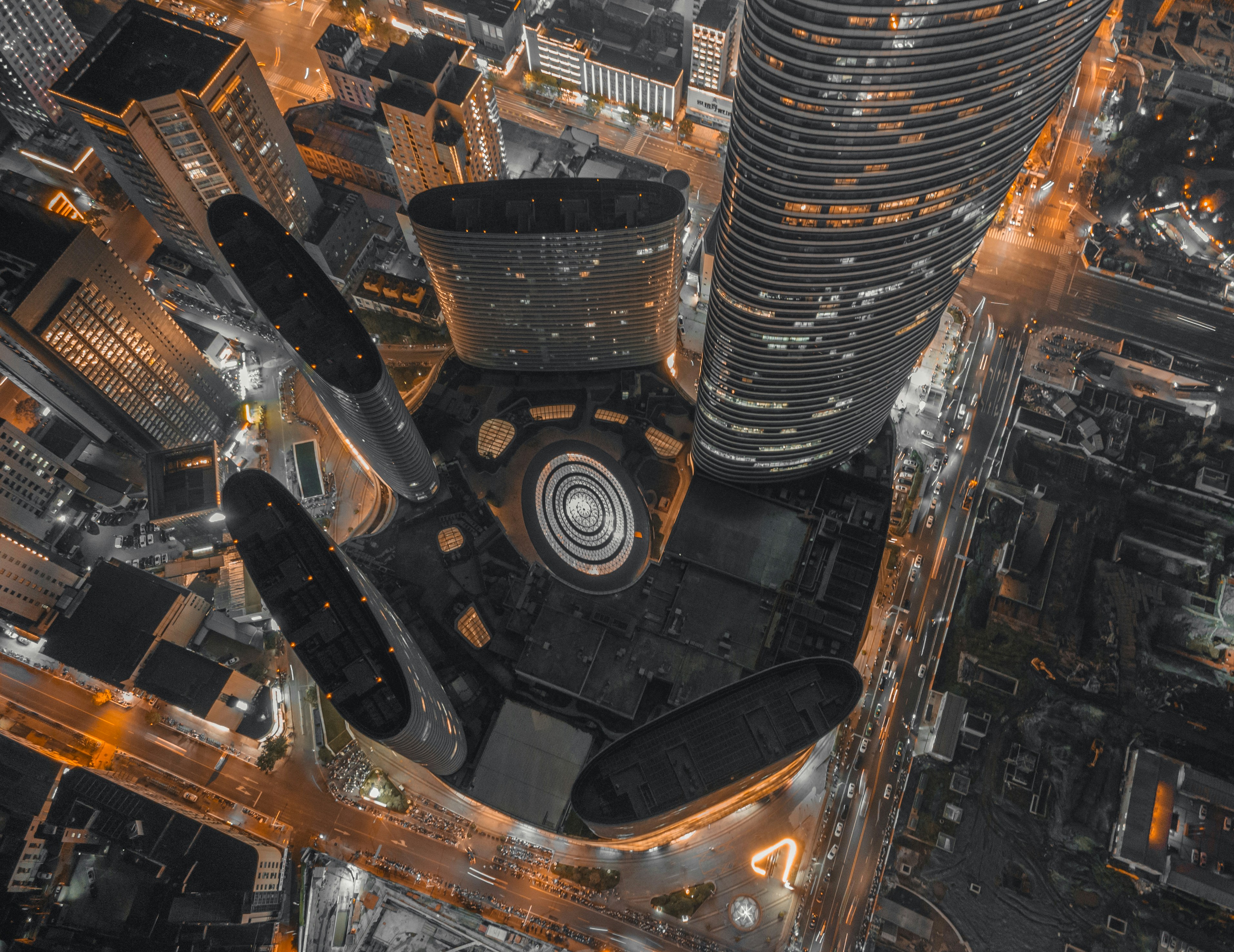 Neon Halo Over the City: Night Drone View of a Circular Plaza Among Skyscrapers