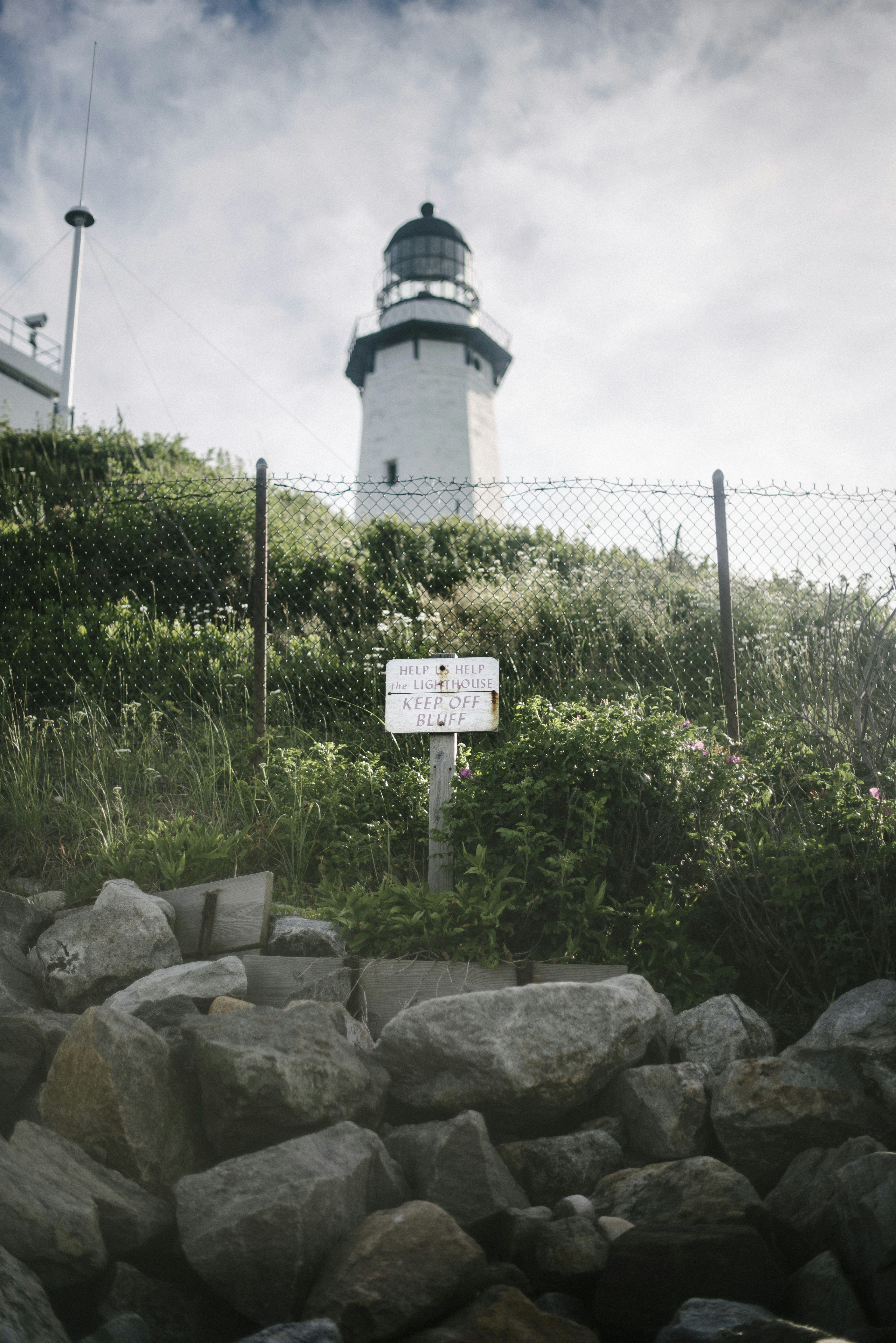 Lighthouse Sentinel: Craggy Forecourt and Sign Mark the Boundary