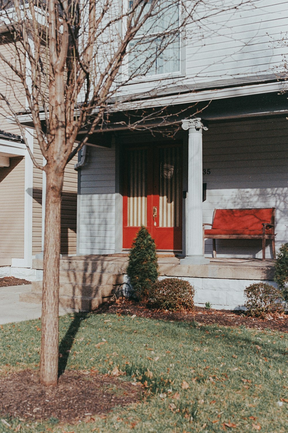 Une maison avec une porte rouge et un arbre devant elle photo – Photo ... Une maison avec une porte rouge et un arbre devant elle photo – Photo ...