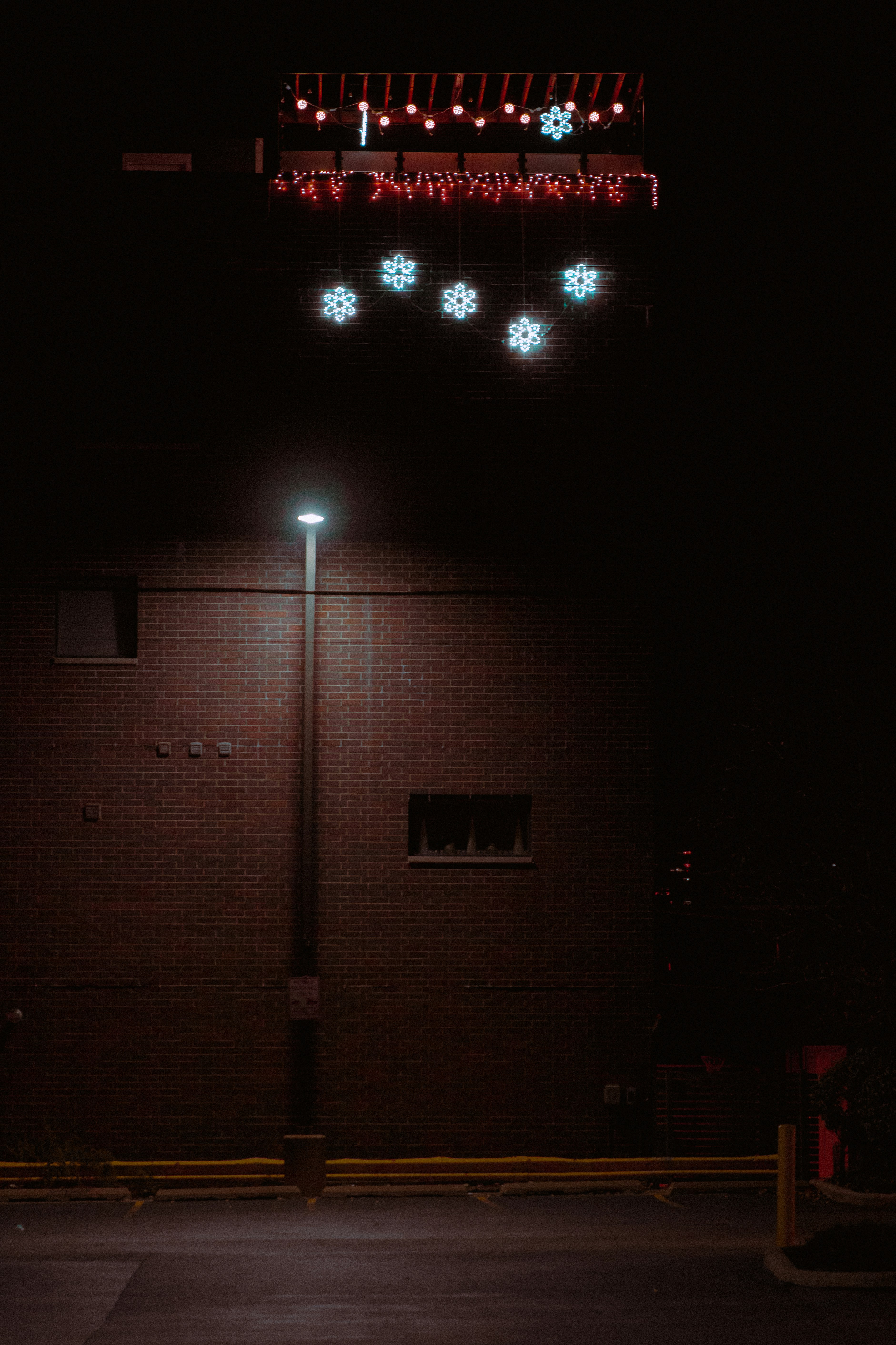 a building with a street light and snowflakes hanging from it's roof