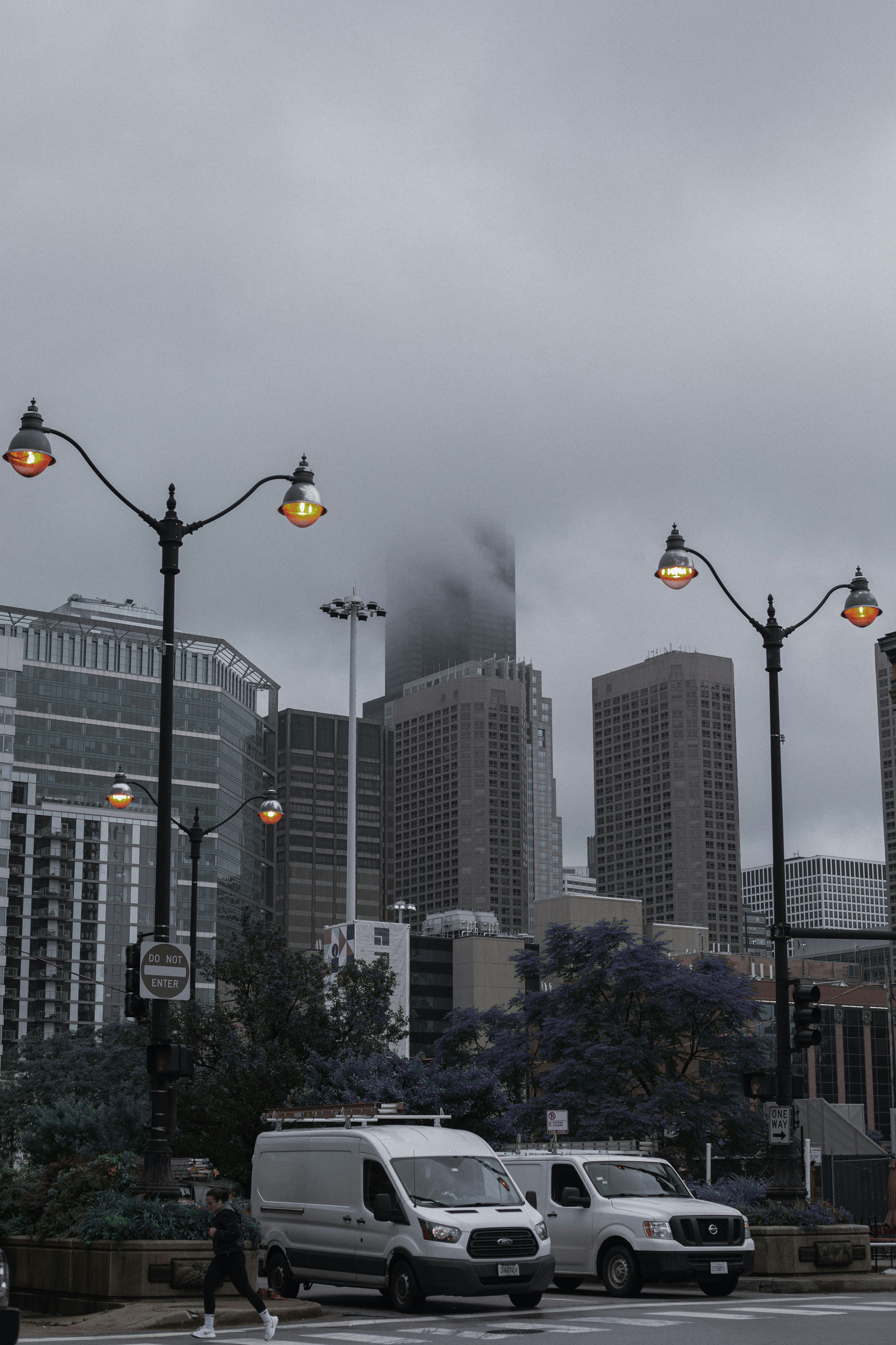 Urban Fog Over Skyline: Streetlamps, Vans, and Tendrils of Cloud