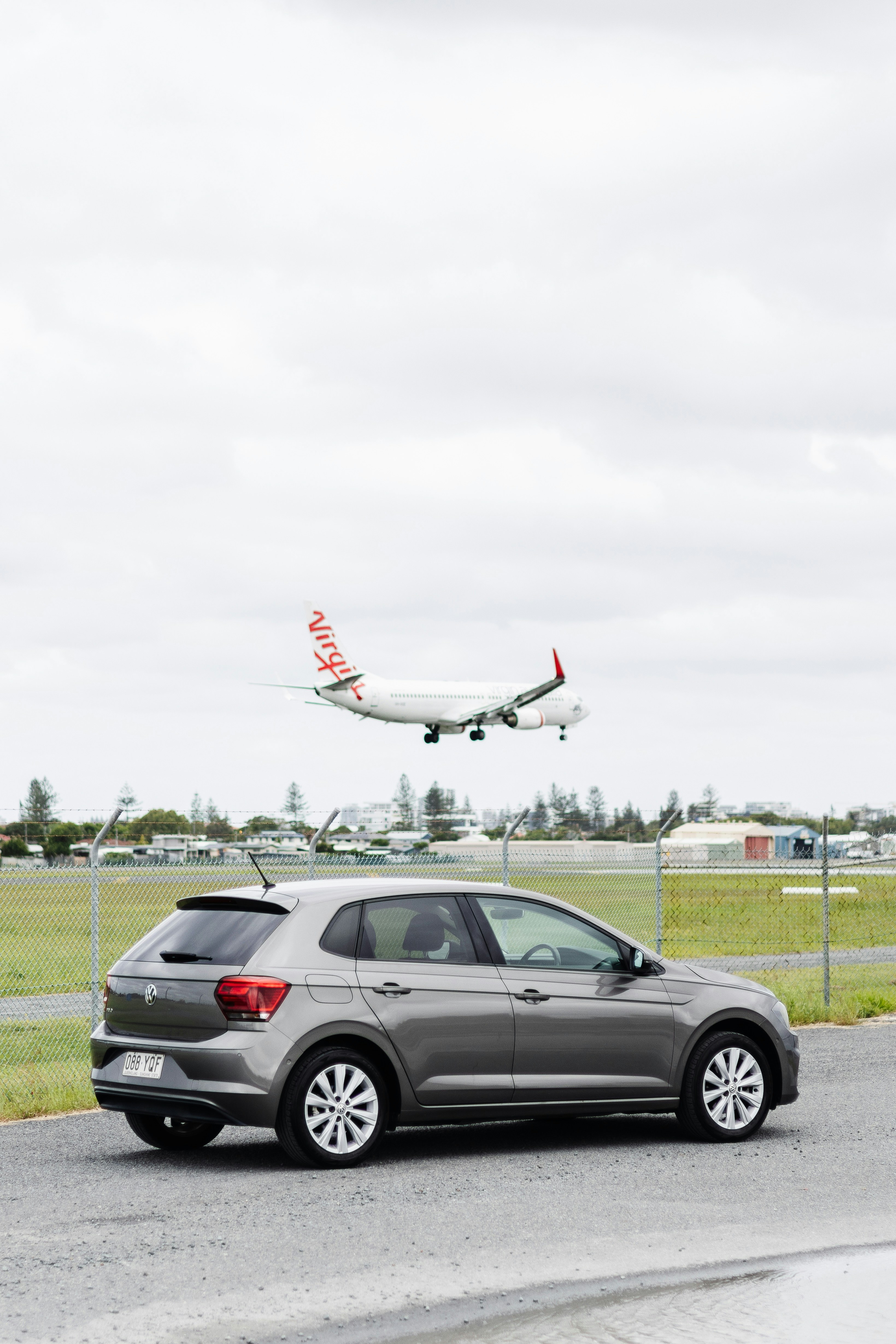A small gray car driving down a road next to an airplane photo – Free ...