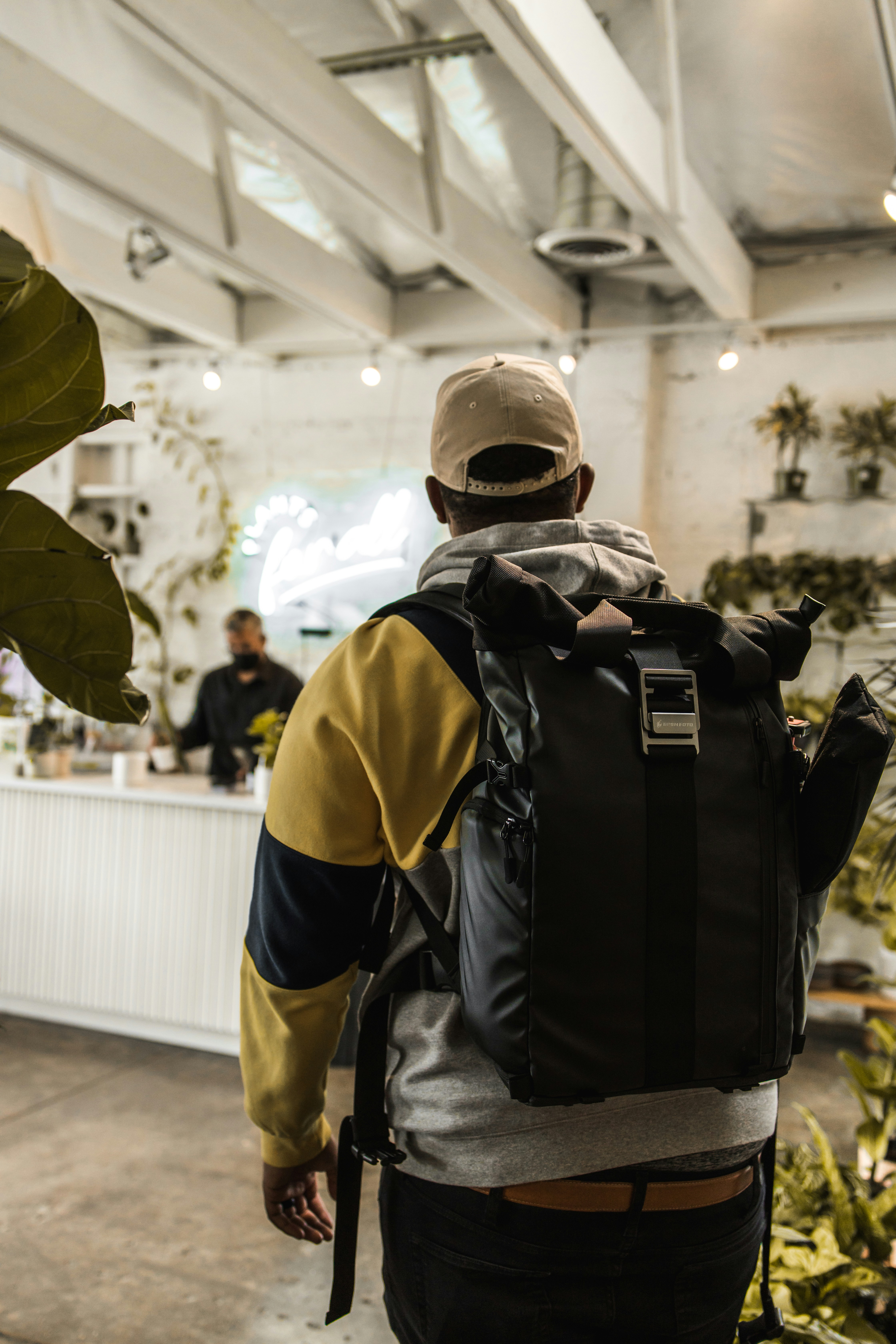 Backpack in a Plant-Filled Café: A Quiet Portrait of Everyday Transit