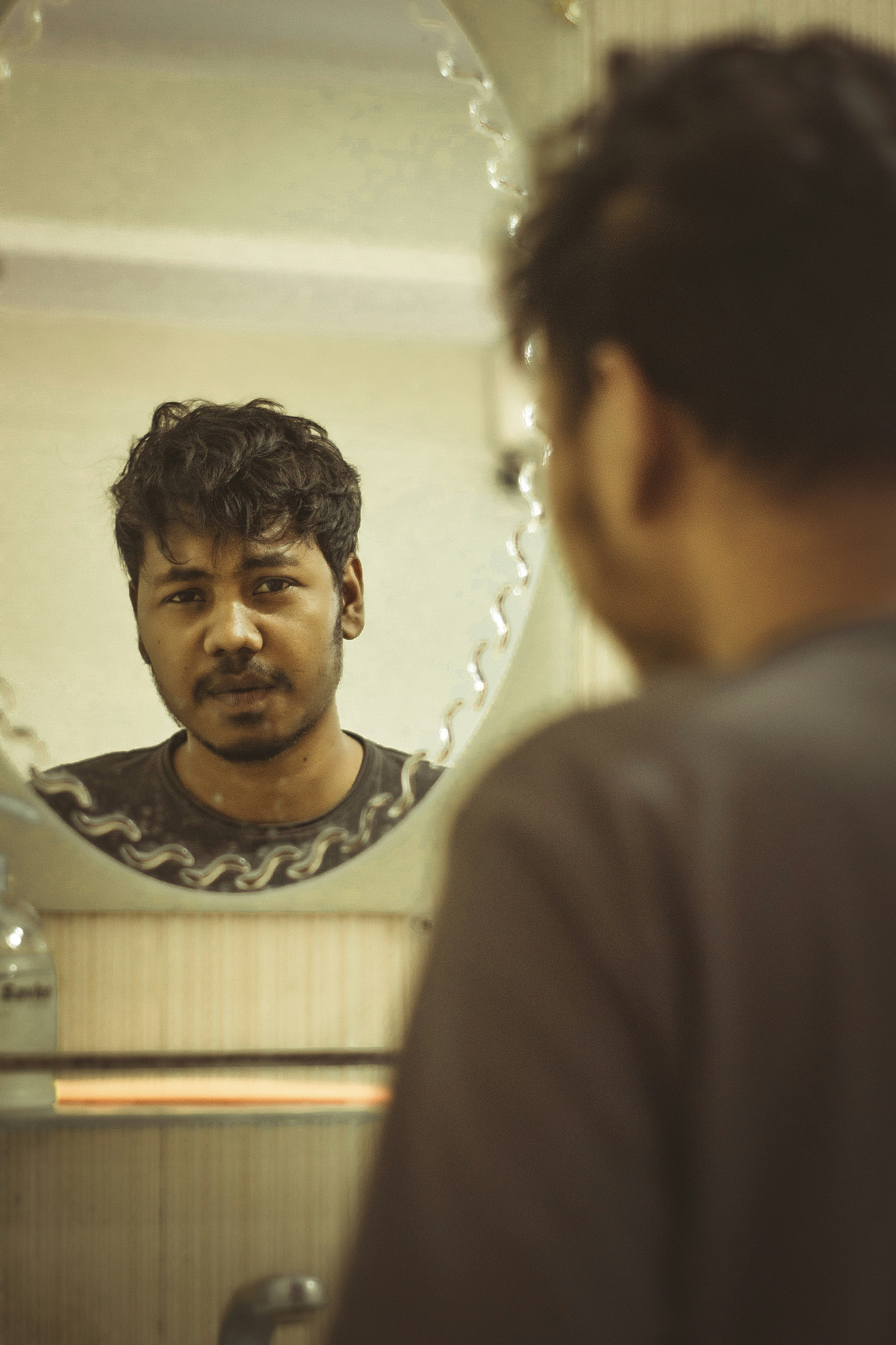 A man looking at himself in the mirror photo – Free Mirror Image on ...