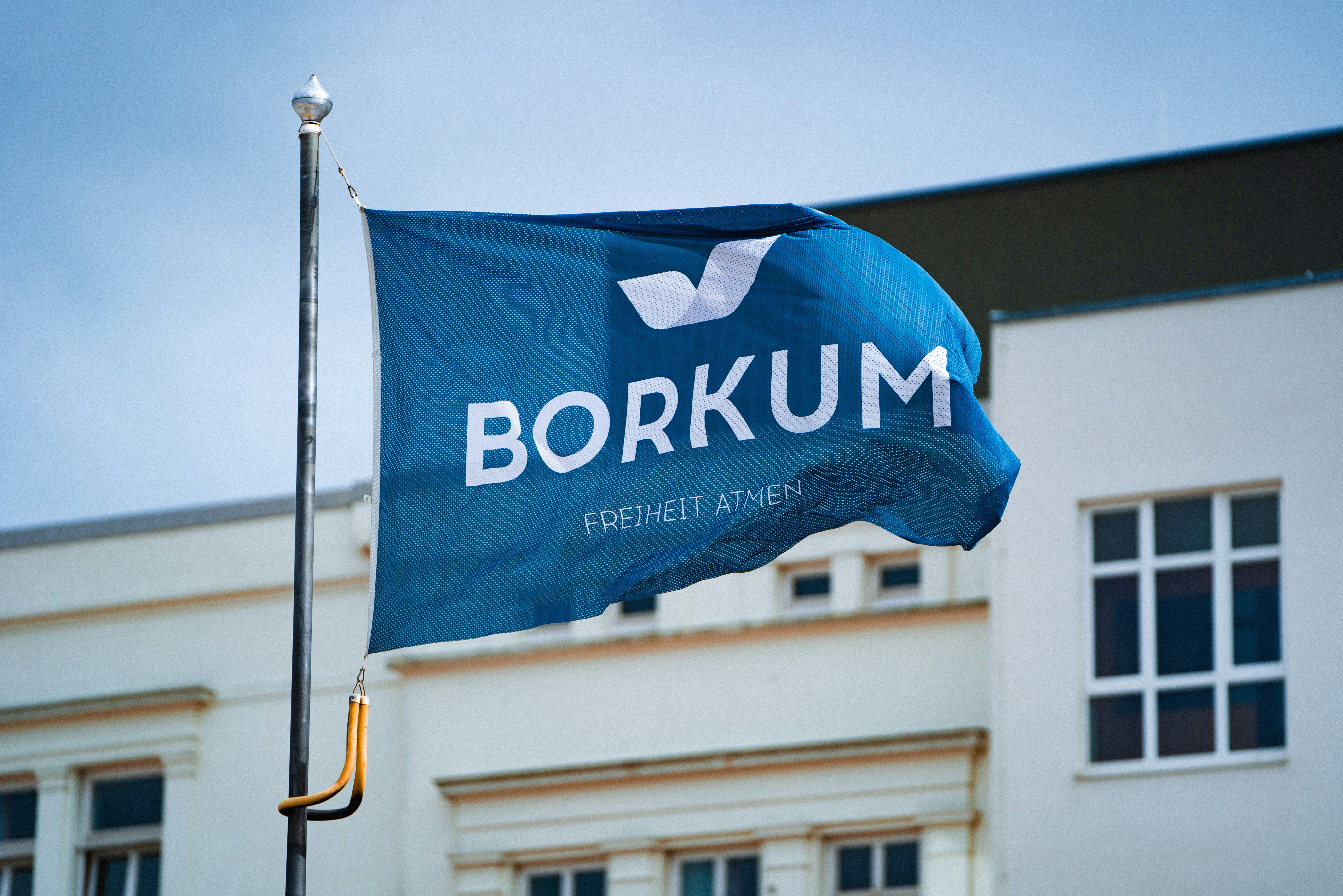 A blue borkum flag flying in front of a building photo – Free Flag ...