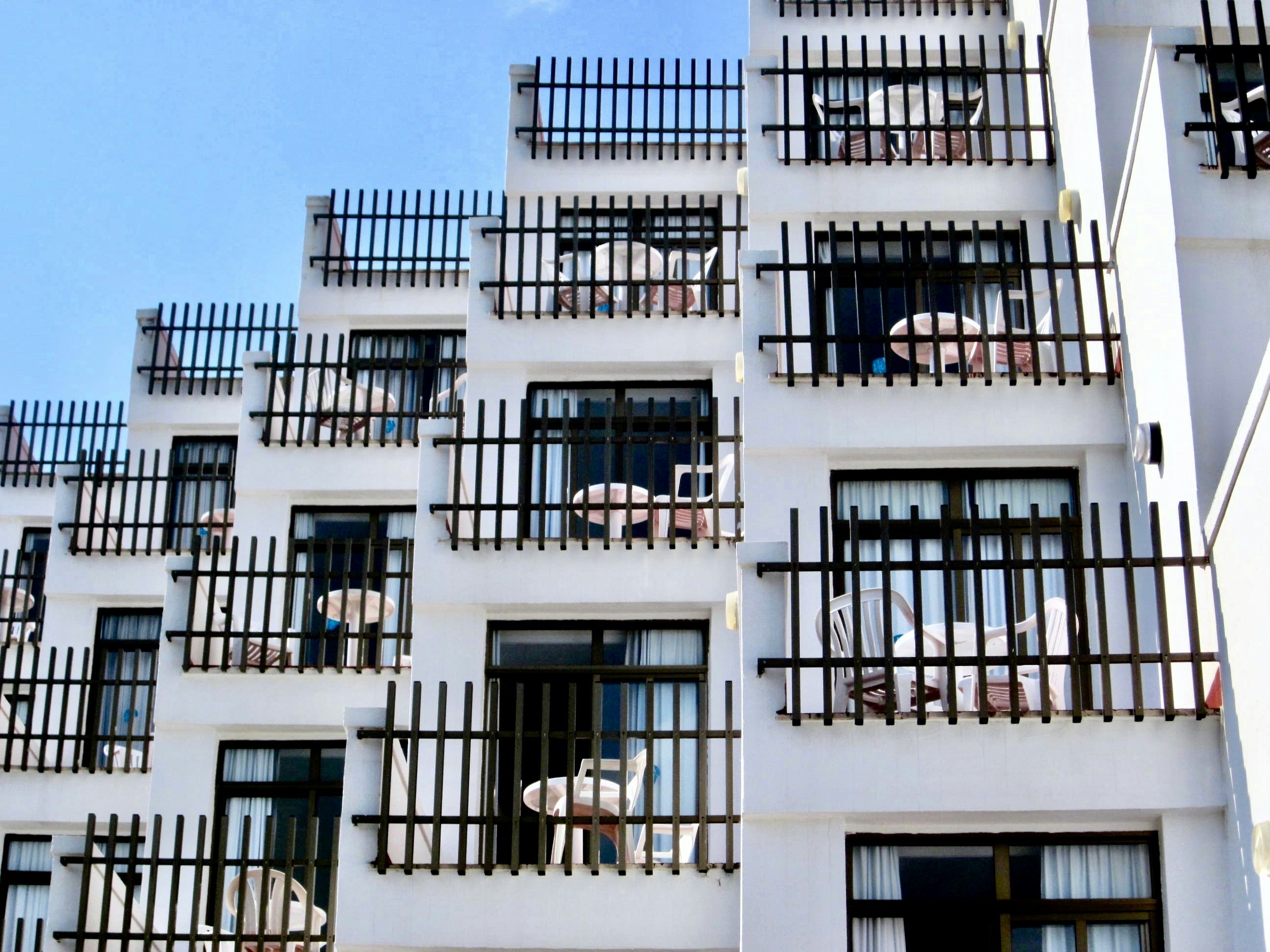 A tall white building with balconies and balconies on the balcon photo ...