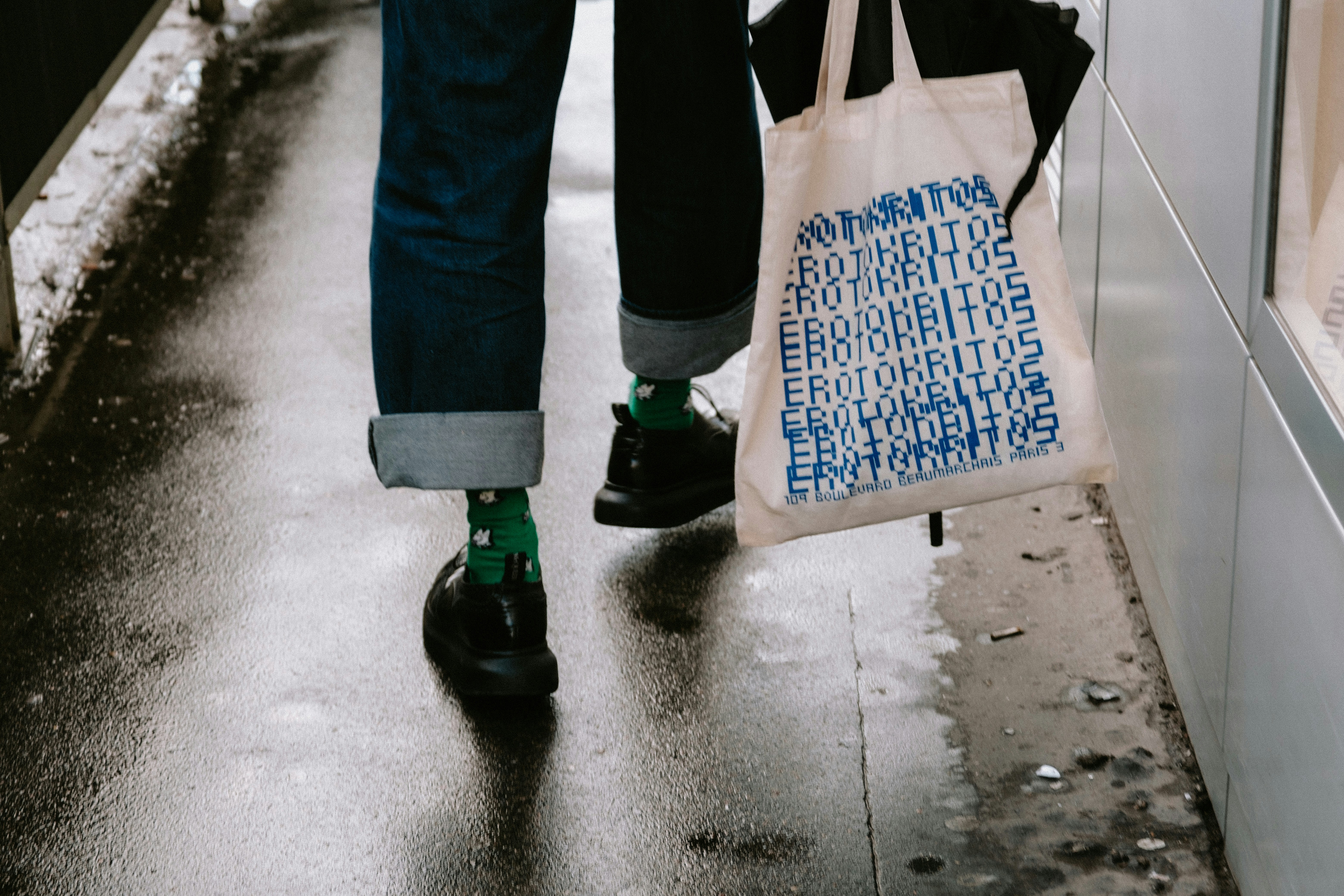 A person walking down a sidewalk carrying a bag photo – Free Paris ...