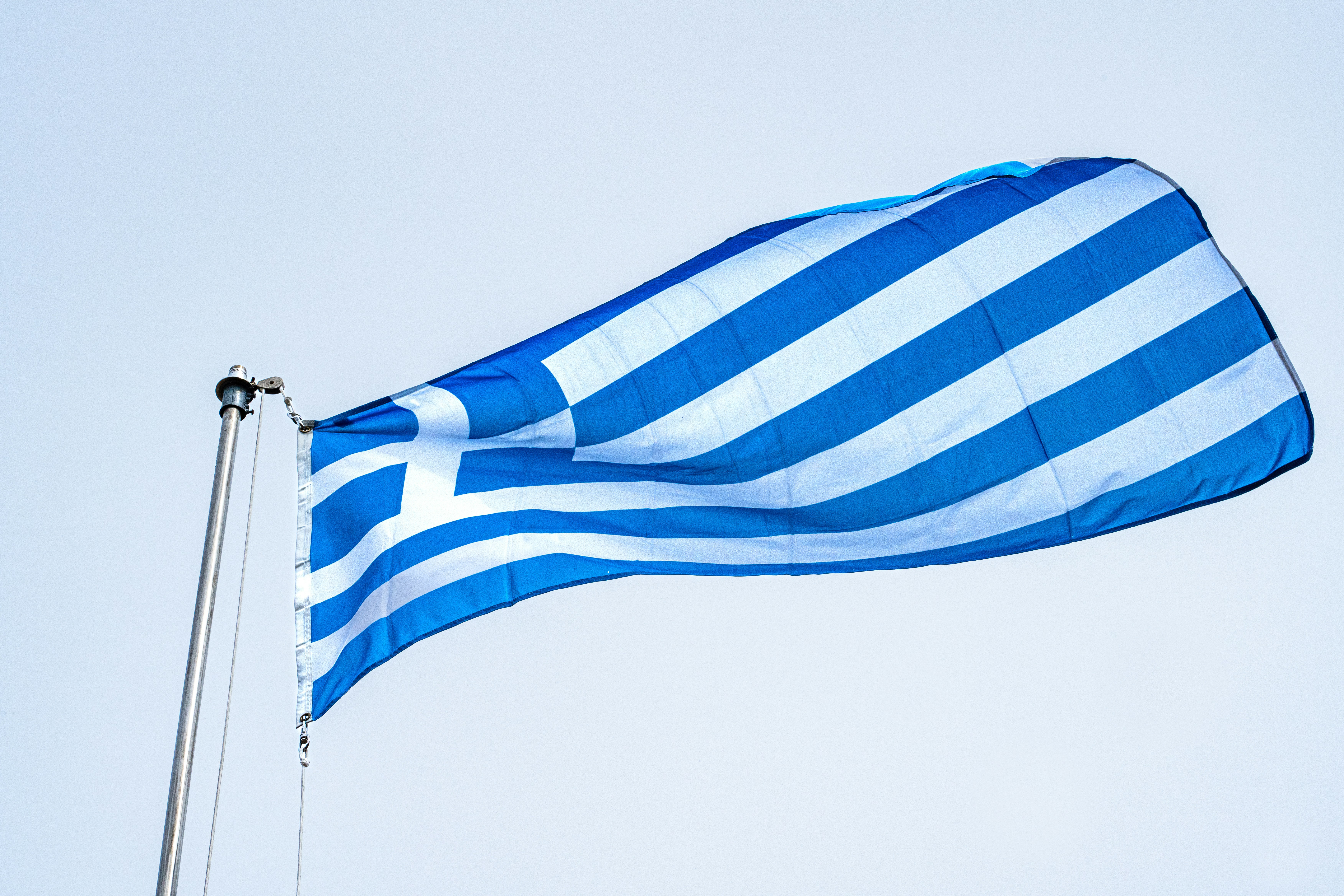 A blue and white flag flying in the wind photo – Free Flag Image on ...