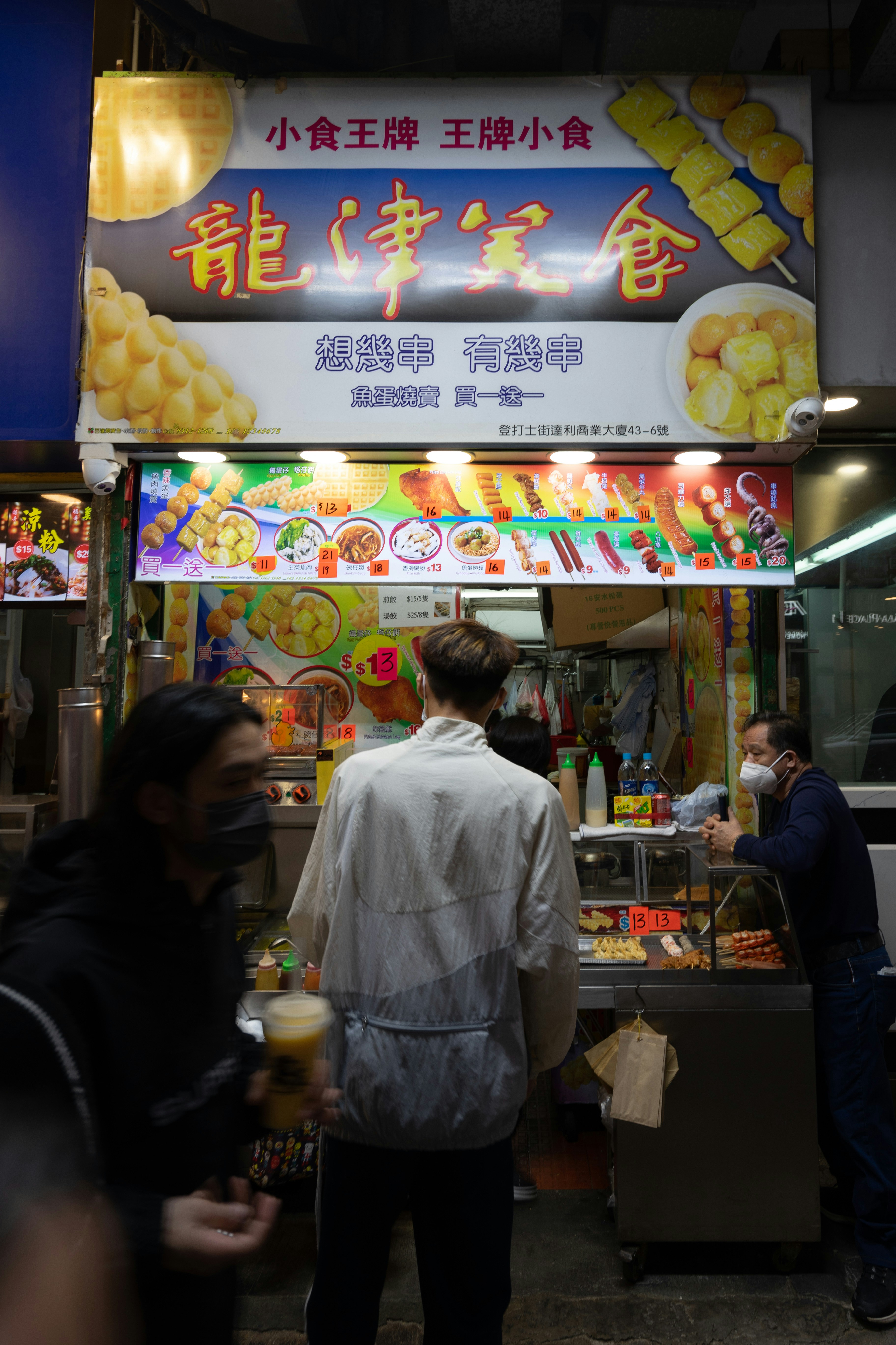 Vibrant street food stall showcasing an array of colorful snacks and dishes, with patrons engaging in the bustling atmosphere.