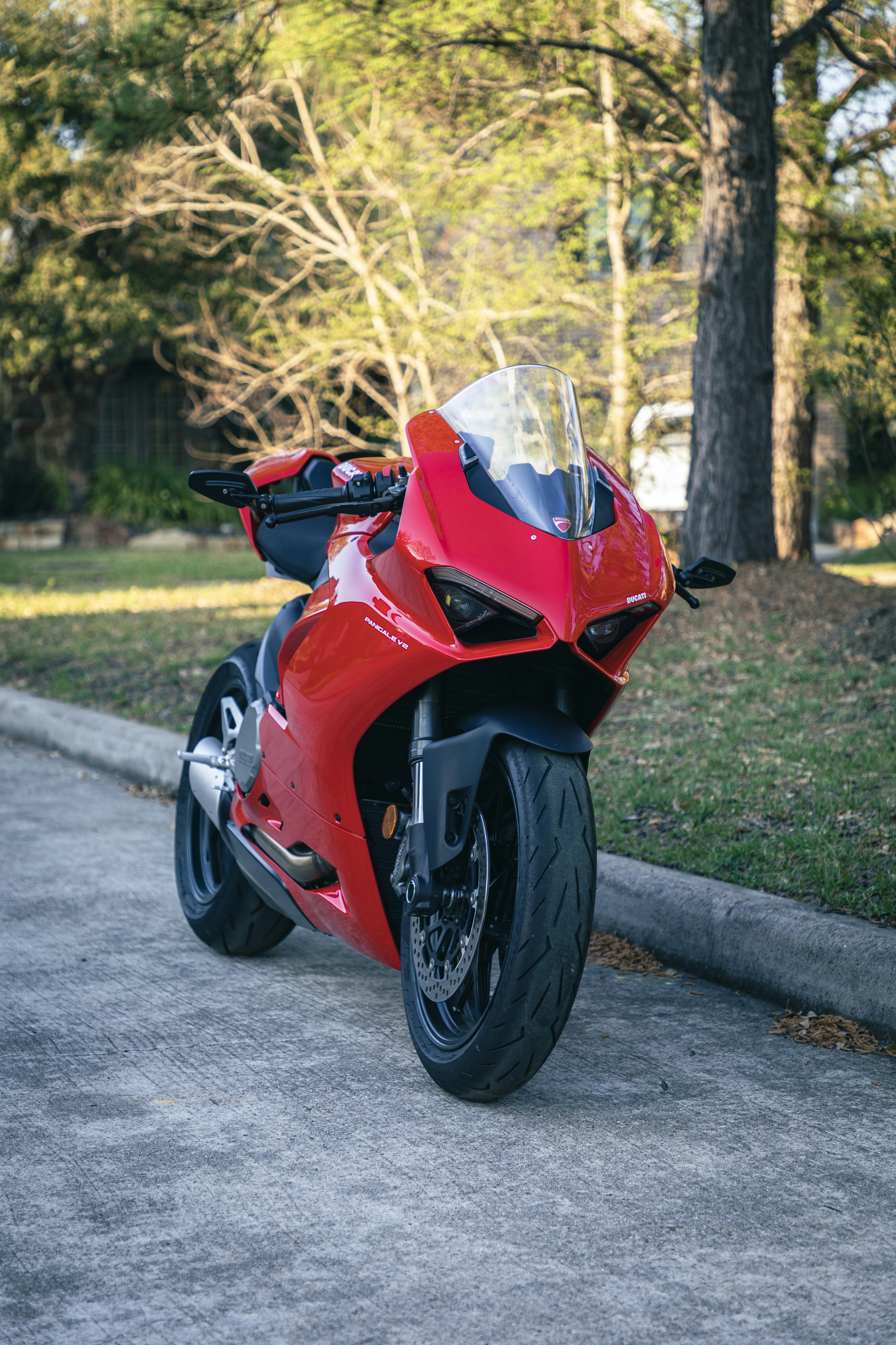 Une moto rouge garée sur le bord de la route photo – Photo Véhicule ...