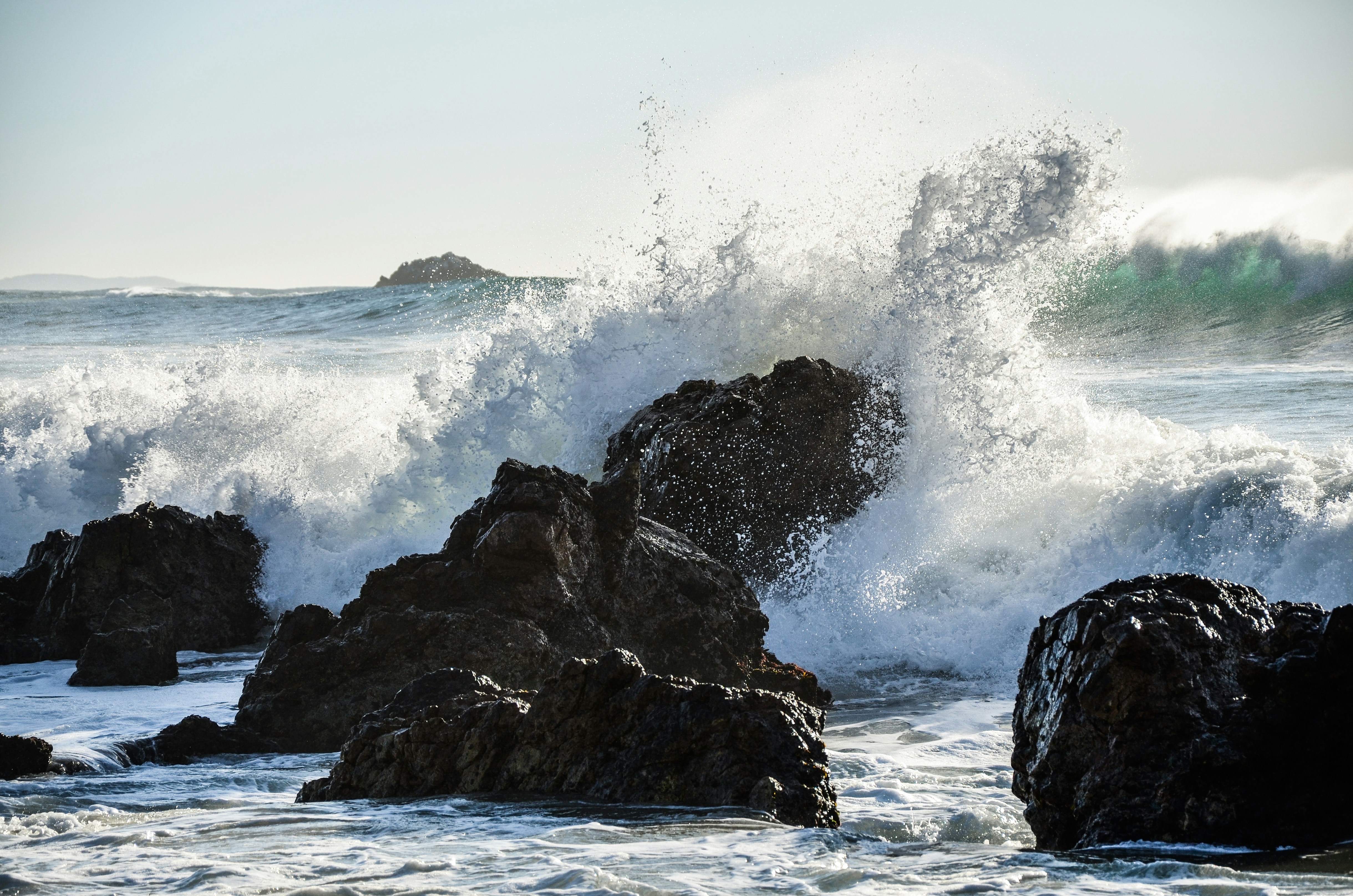 A large wave crashing over rocks in the ocean photo – Free Australia ...