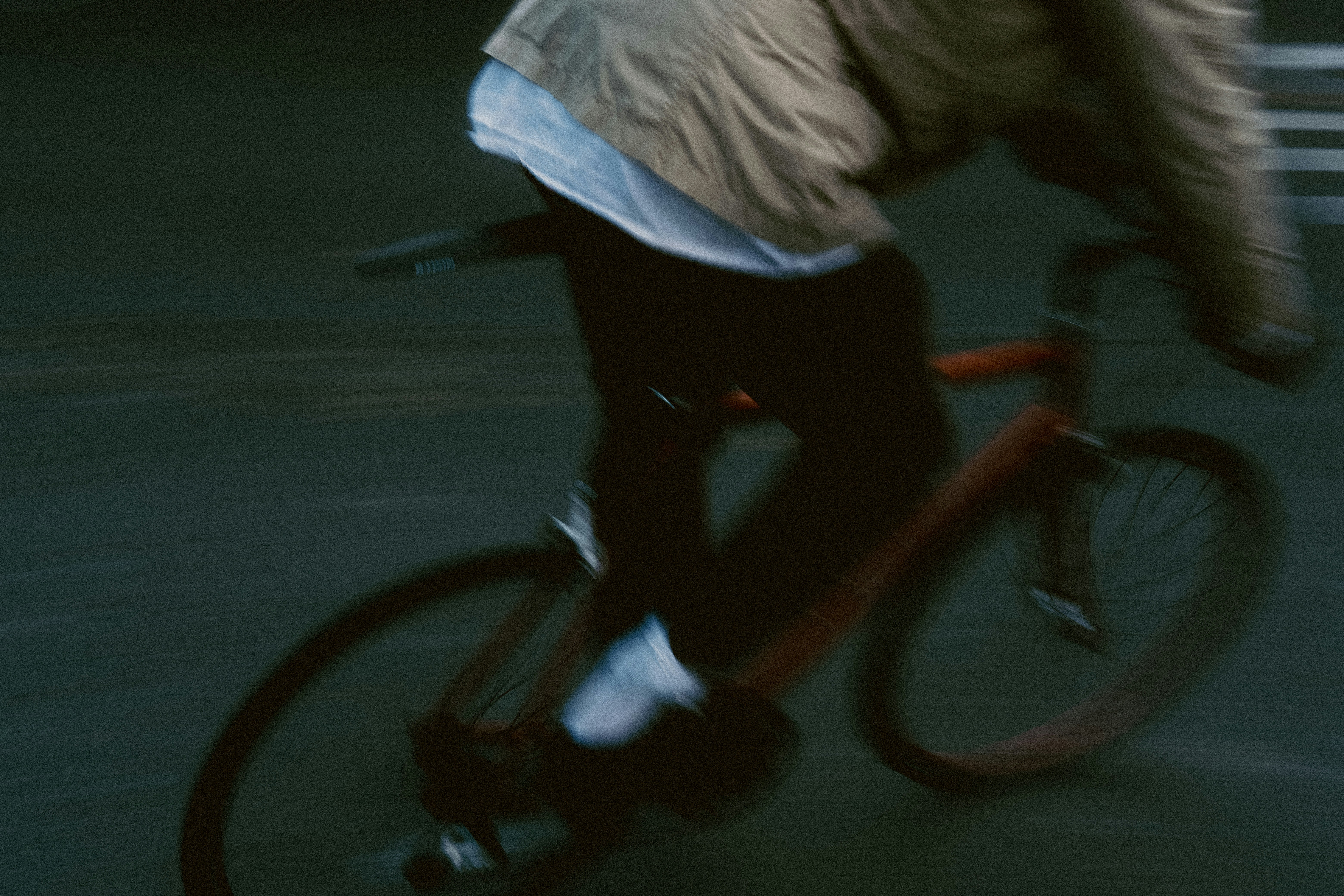 A cyclist in motion, captured with a dynamic blur that emphasizes speed and movement. The scene conveys the essence of urban cycling.